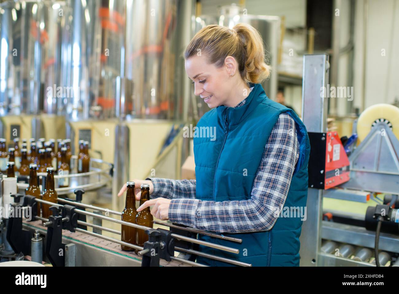 female worker with bottle of beers in factory Stock Photo - Alamy