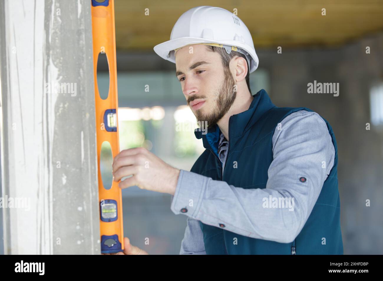 apprentice builder using spirit level Stock Photo - Alamy