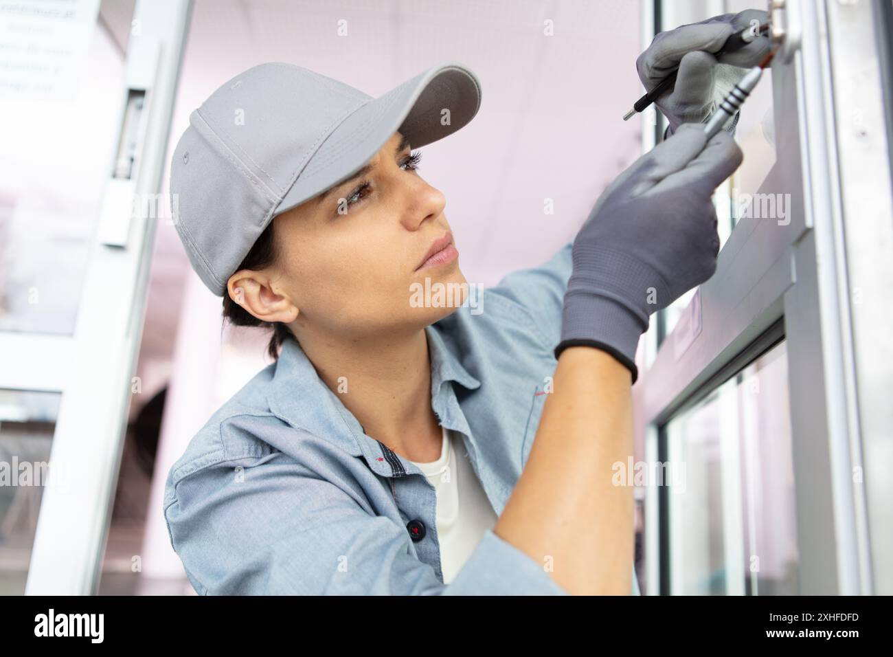 happy female builder using a screwdriver on a door Stock Photo - Alamy
