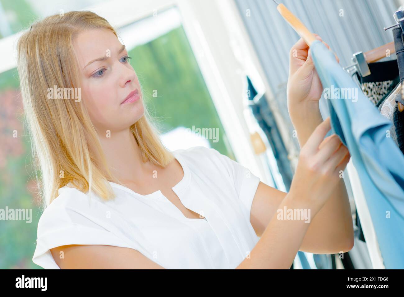 a woman is handling a clothing Stock Photo - Alamy