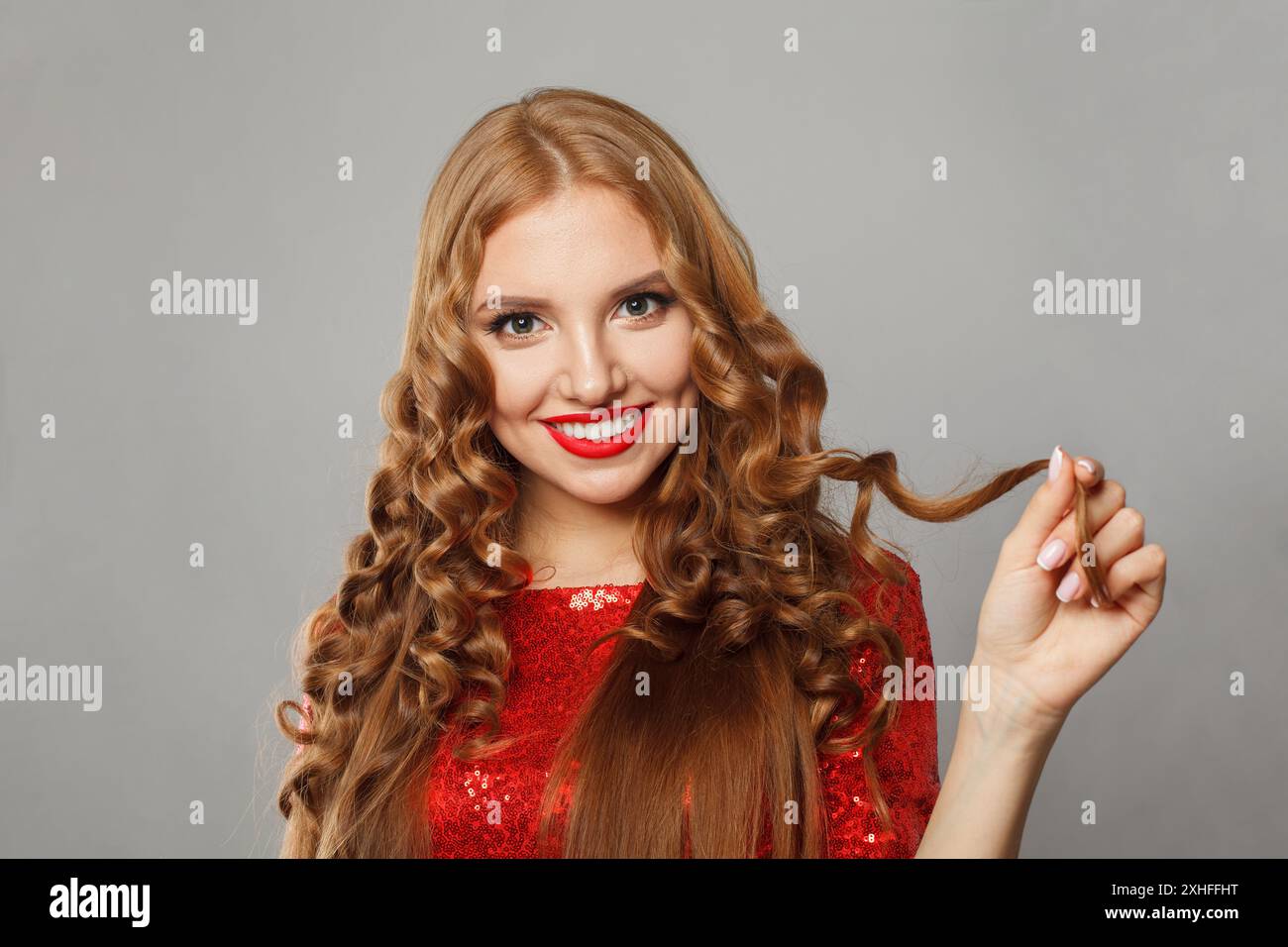 Happy young adult model woman with long curly brown hairstyle posing ...