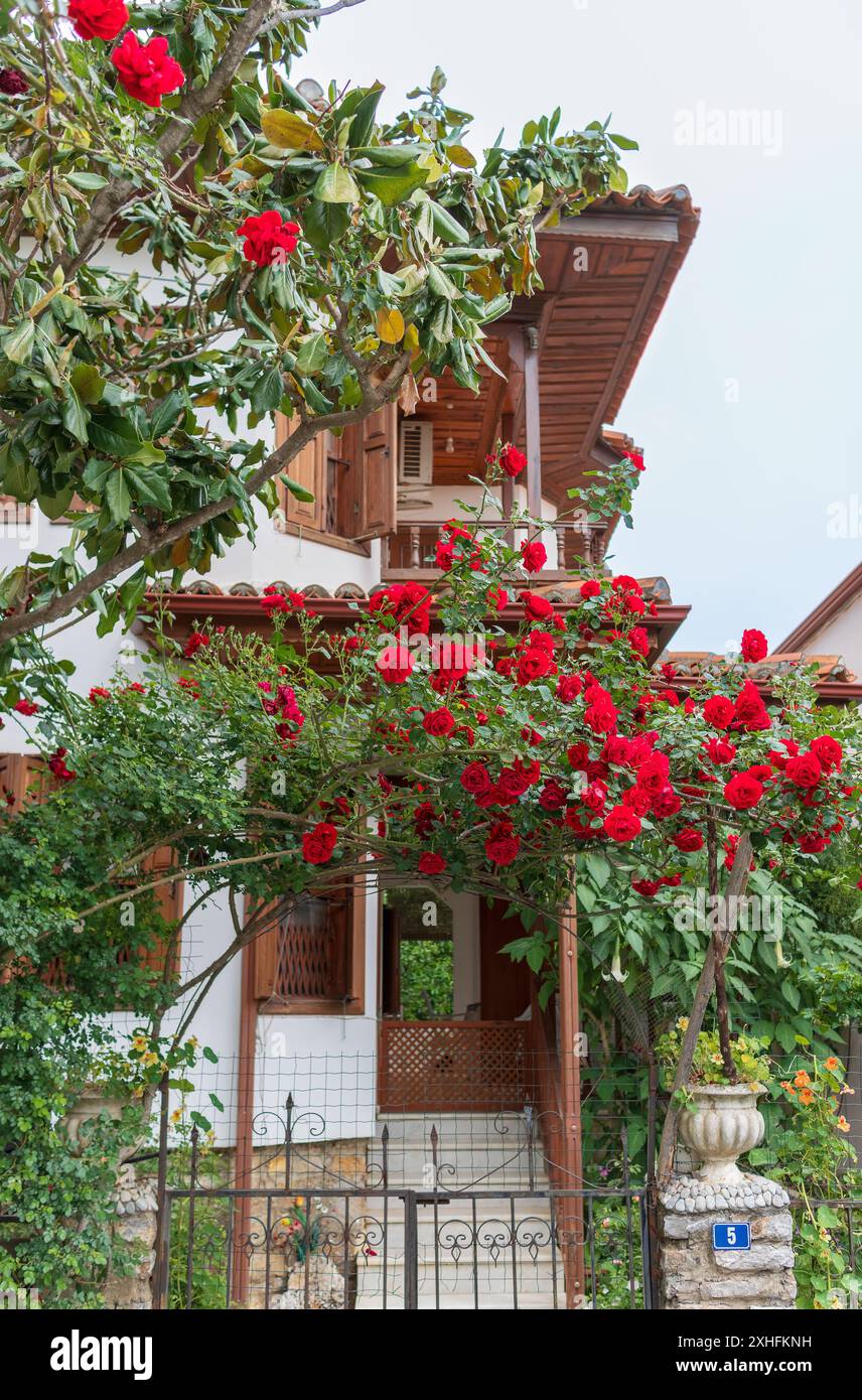 Typical Turkish architecture of a red rose entwined house in small town ...