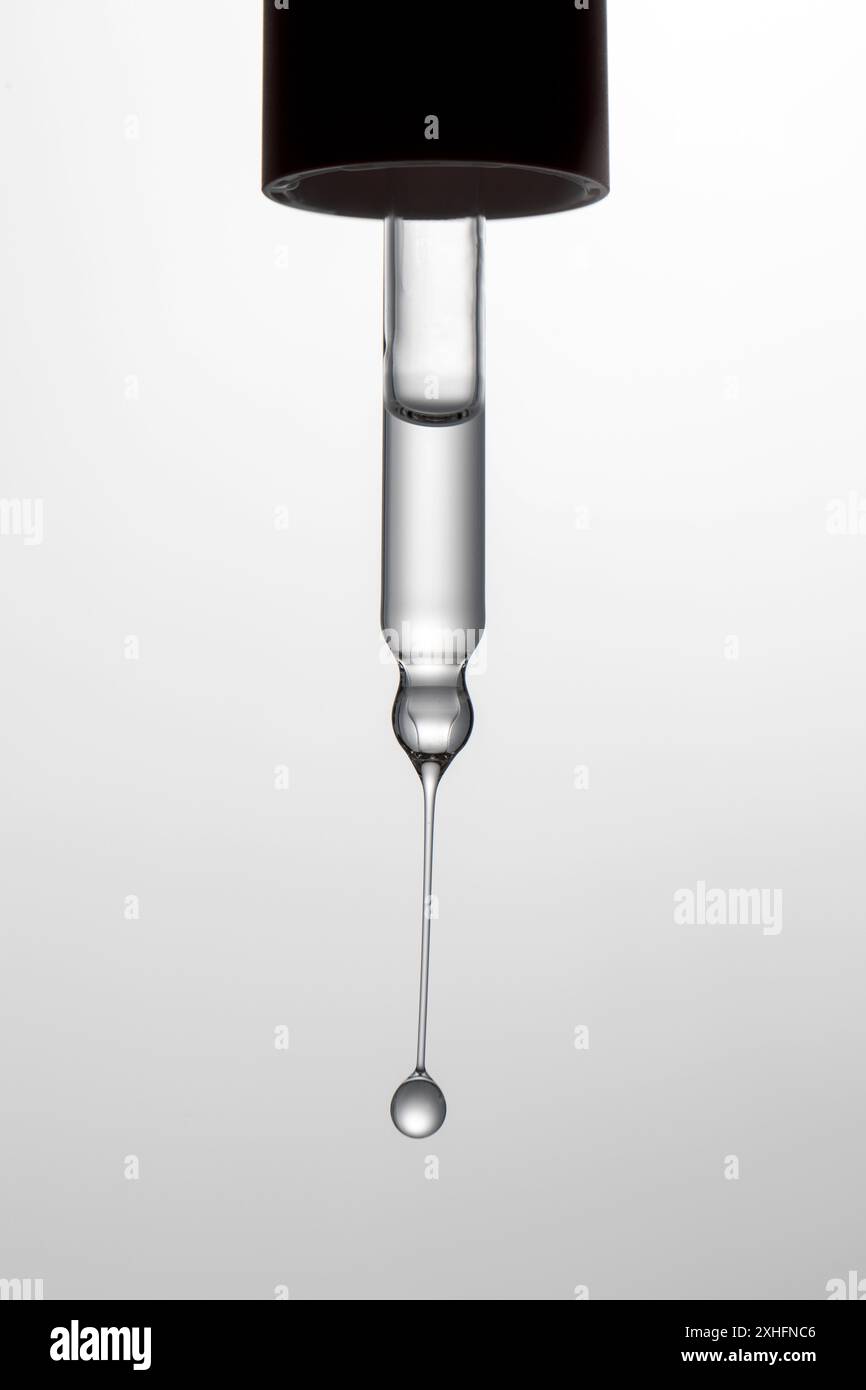 Dripping antiaging serum with pipette on white background Stock Photo ...