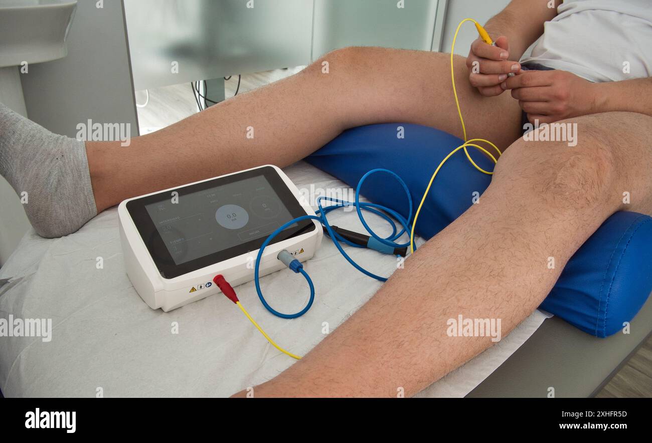 A photo of a neuro modulation machine between the legs of a patient ...