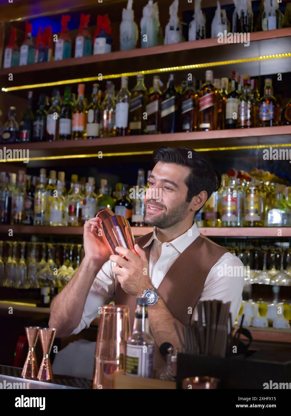 Bartender is making cocktail with talking customer at bar counter Stock ...