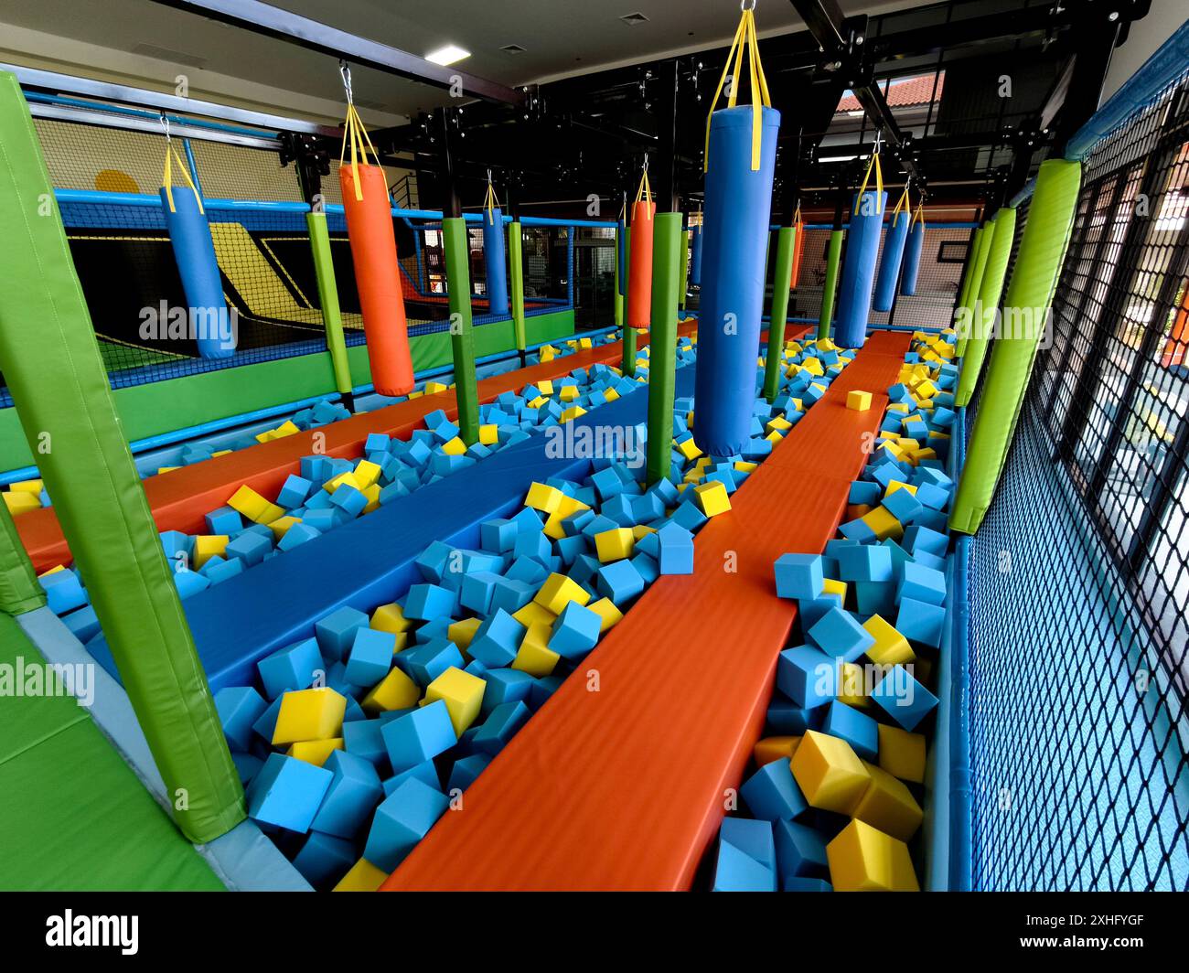 Trampoline park has blue and yellow foam cubes for kids fun Stock Photo ...