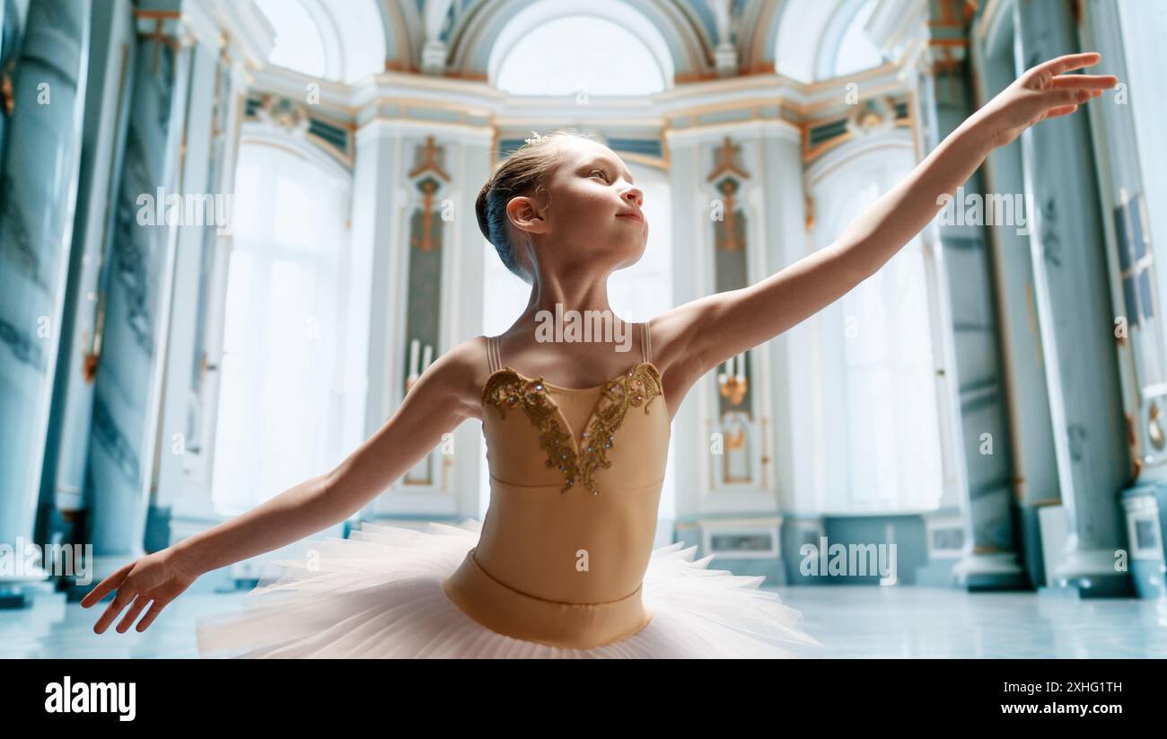 Cute little girl dreaming of becoming a ballerina. Child girl in a tutu dancing in the ball room ...