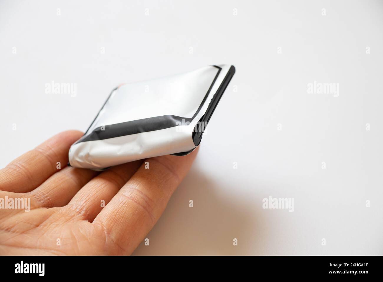 A telephone battery swollen from overheating in a girl s hands lies on ...