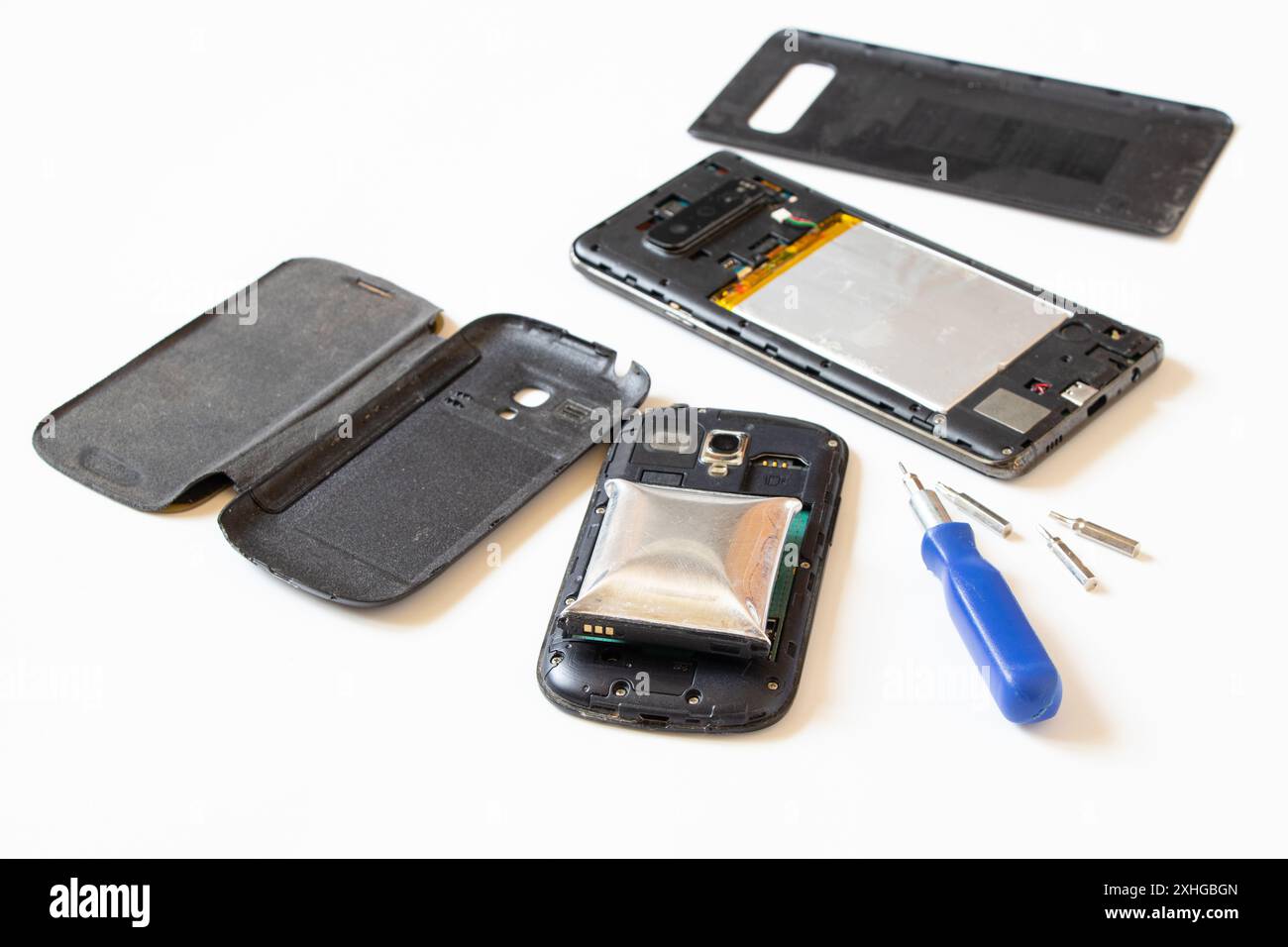 A telephone battery swollen from overheating and a disassembled phone ...