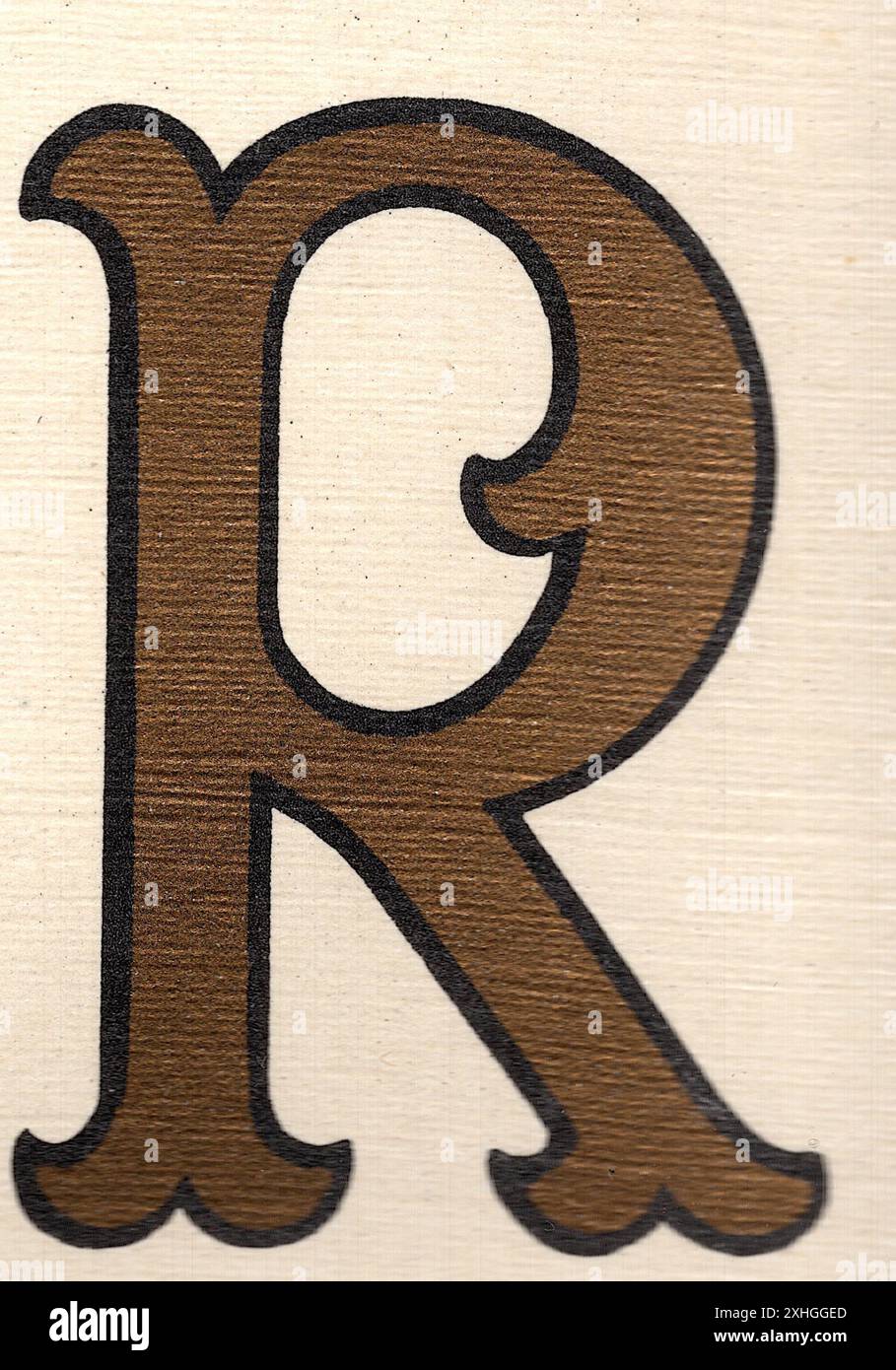 A decorative antique capital letter R in gold with a black outline on a ...