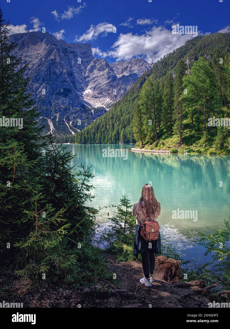 Travel summer vacation concept. Single traveler visits Braies lake Lago ...