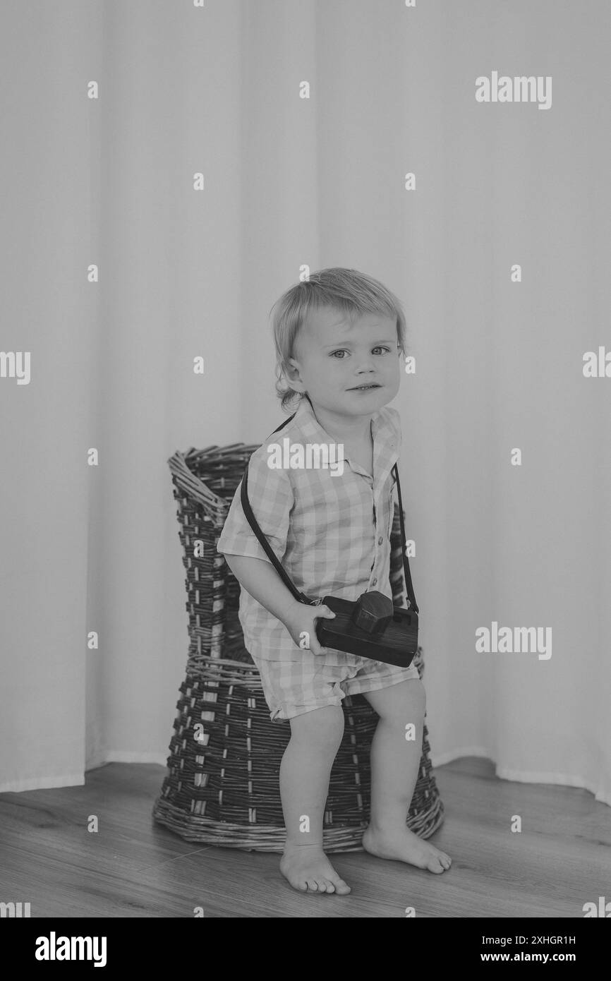 little boy sitting on a wicker chair Stock Photo - Alamy