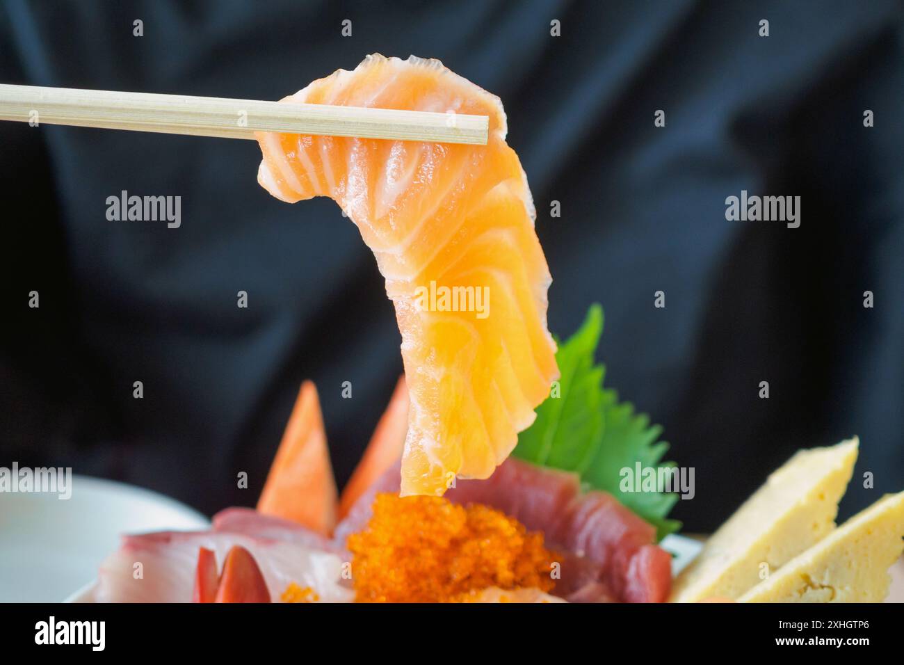 Salmon slice in chopsticks, Eating Sashimi Rice Bowl Chirashi Don ...