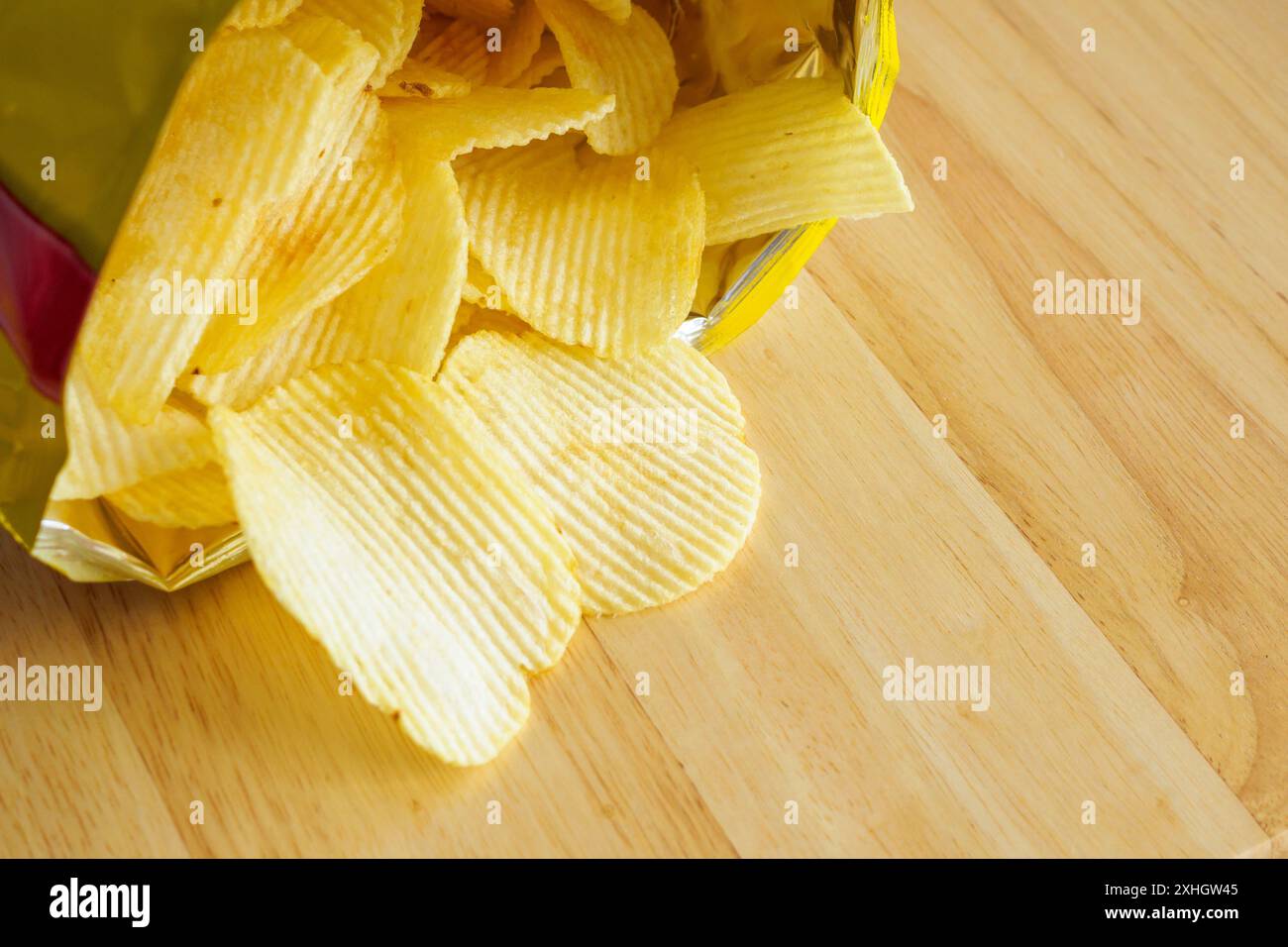 potato chips open bag on wood table Stock Photo - Alamy
