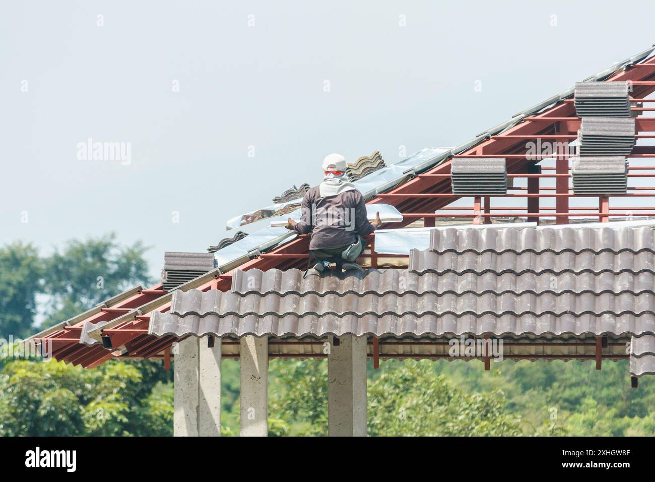 Construction roofer installing roof tiles at house building site Stock ...