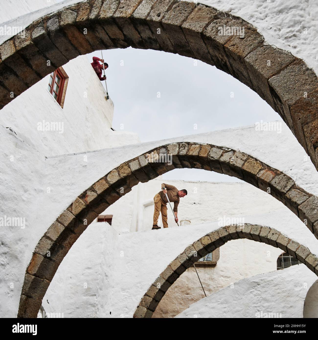 Workers painting the Monastery Of St. John Hora, Patmos island, Greece ...