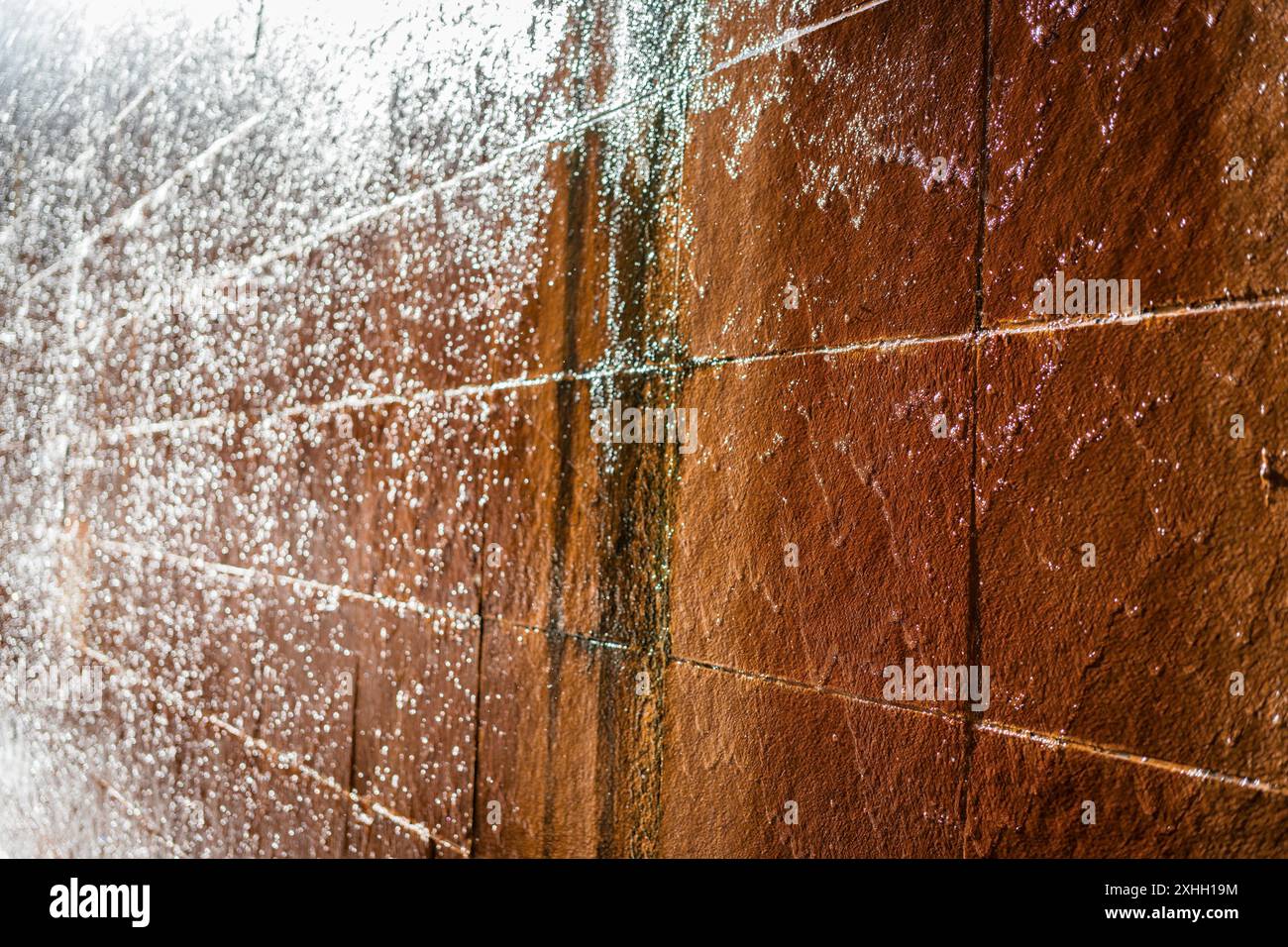 A close-up view of a textured waterfall cascading down a stone wall ...