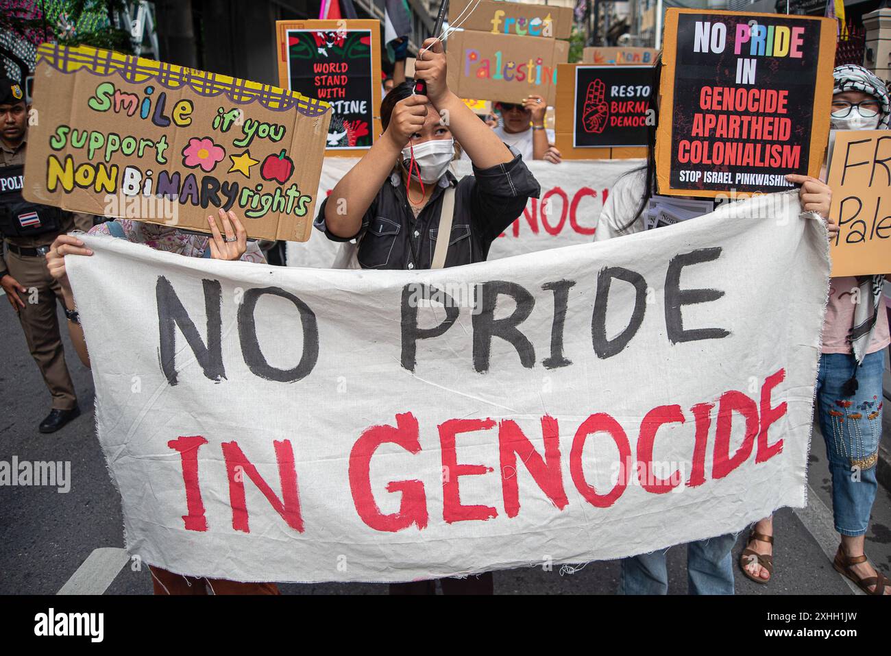 Participants hold a banner and placards expressing their opinions ...