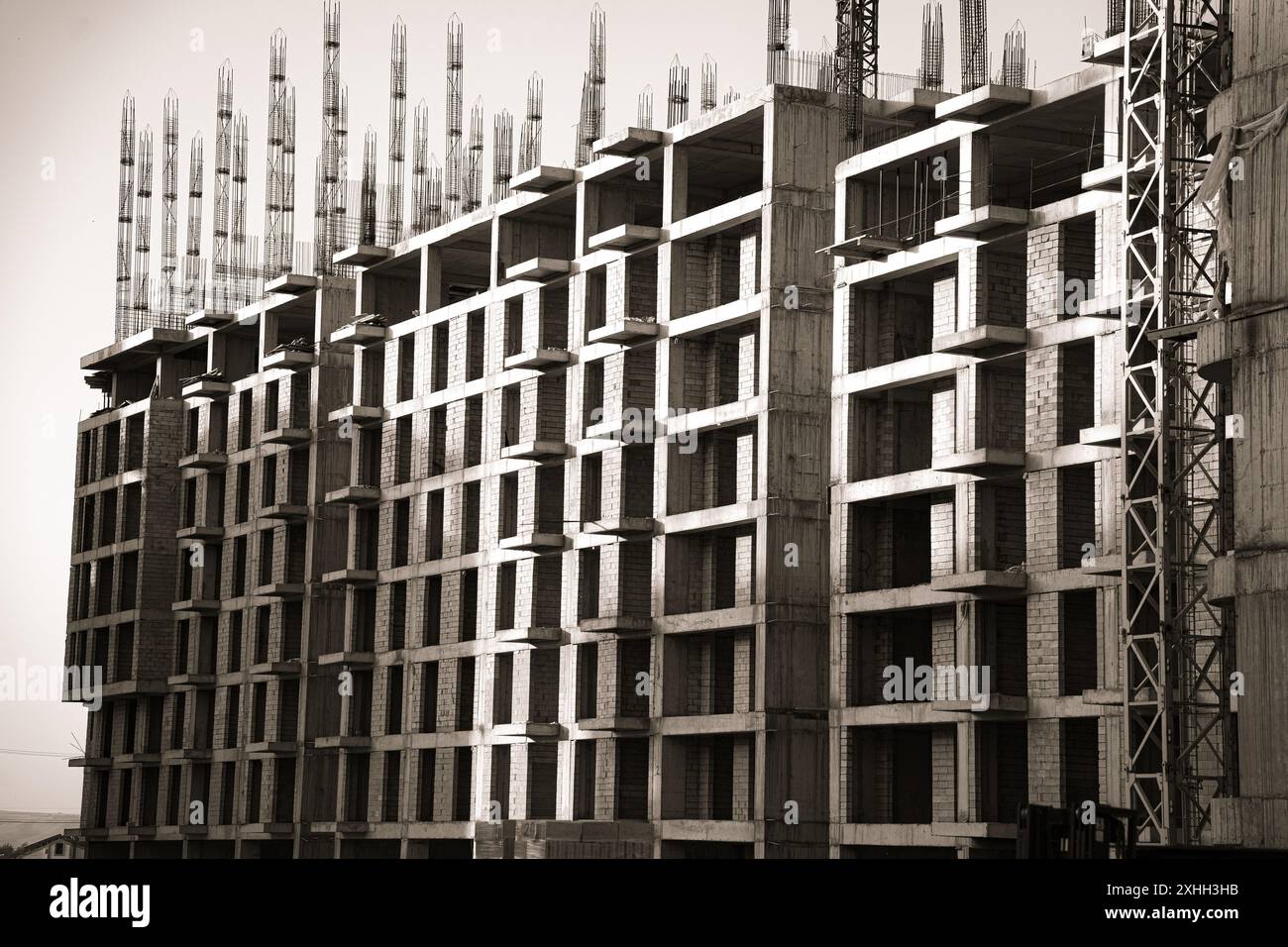 A sepia-toned image of a multi-story building under construction with ...