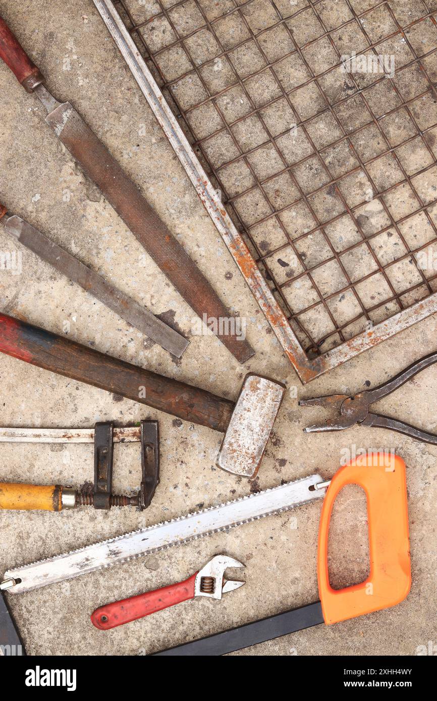 Old construction tools laid out on a concrete background, top view ...