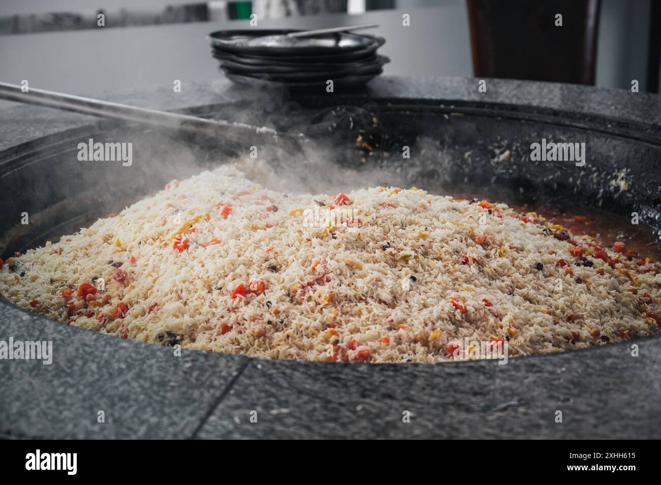 traditional oriental Asian Uzbek rice pilaf in cauldron in the kitchen ...