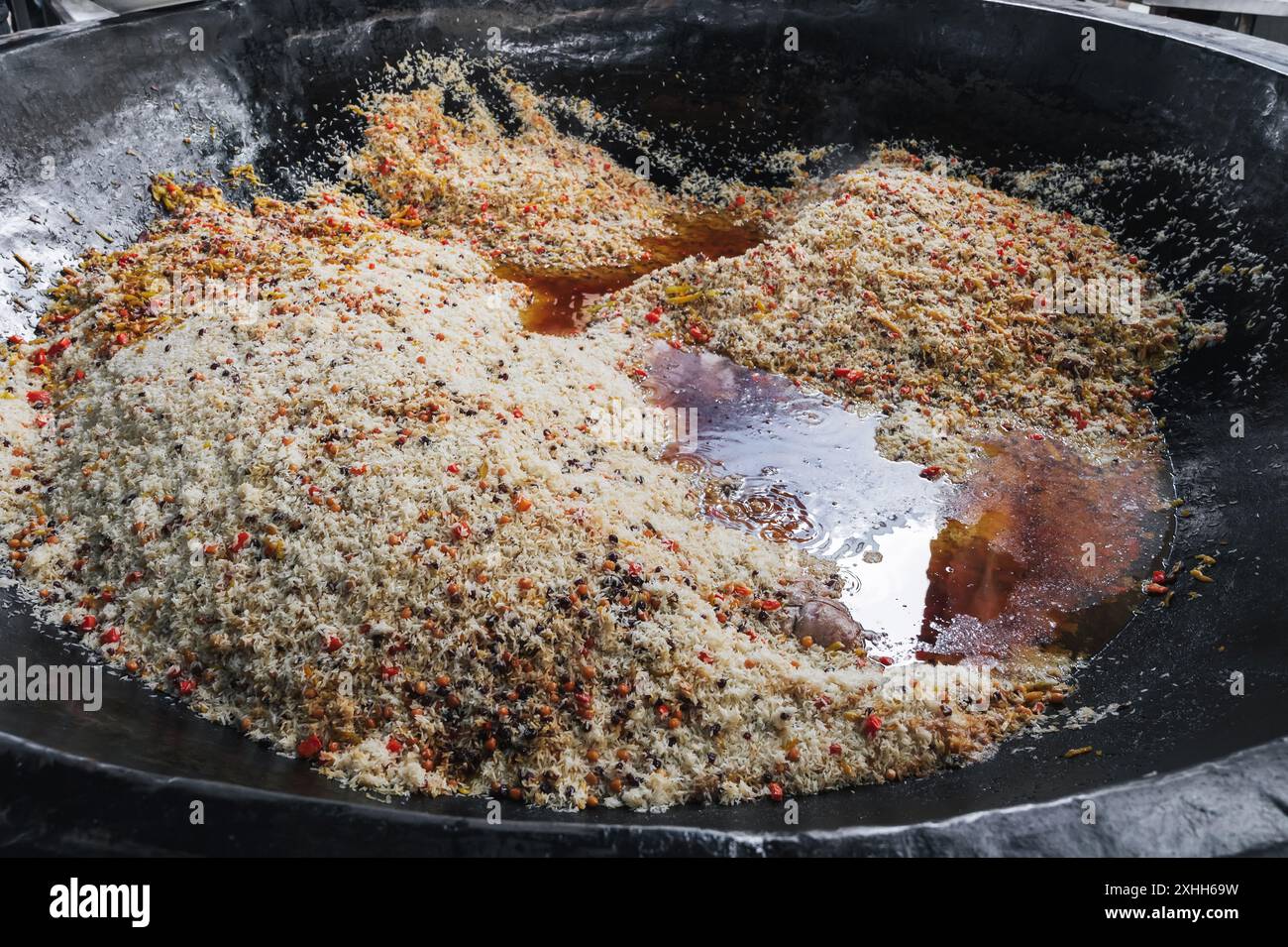 traditional Asian Uzbek rice pilaf in a big cauldron in the kitchen in ...