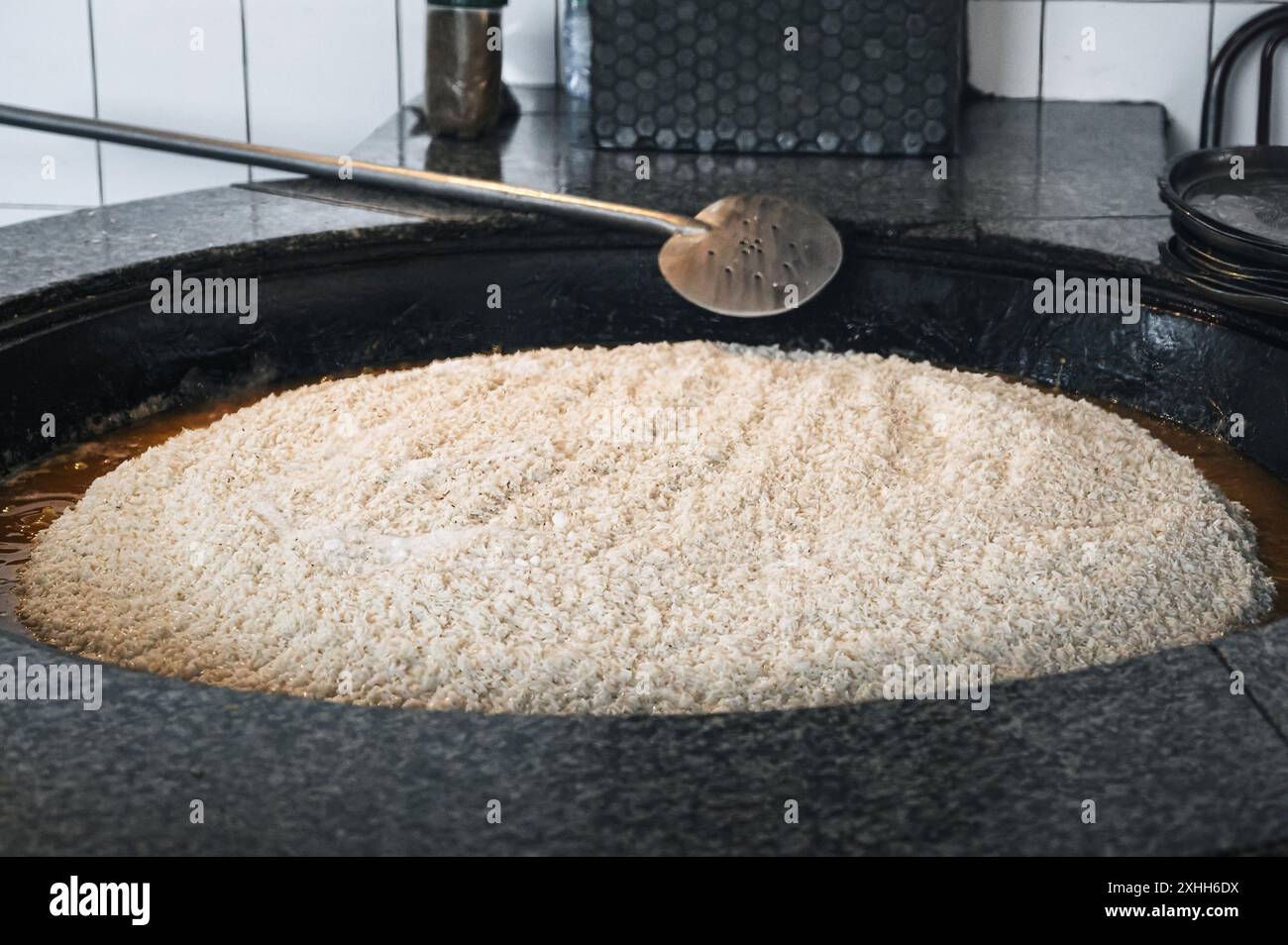 cooking traditional oriental Uzbek rice pilaf in a cauldron. Central ...