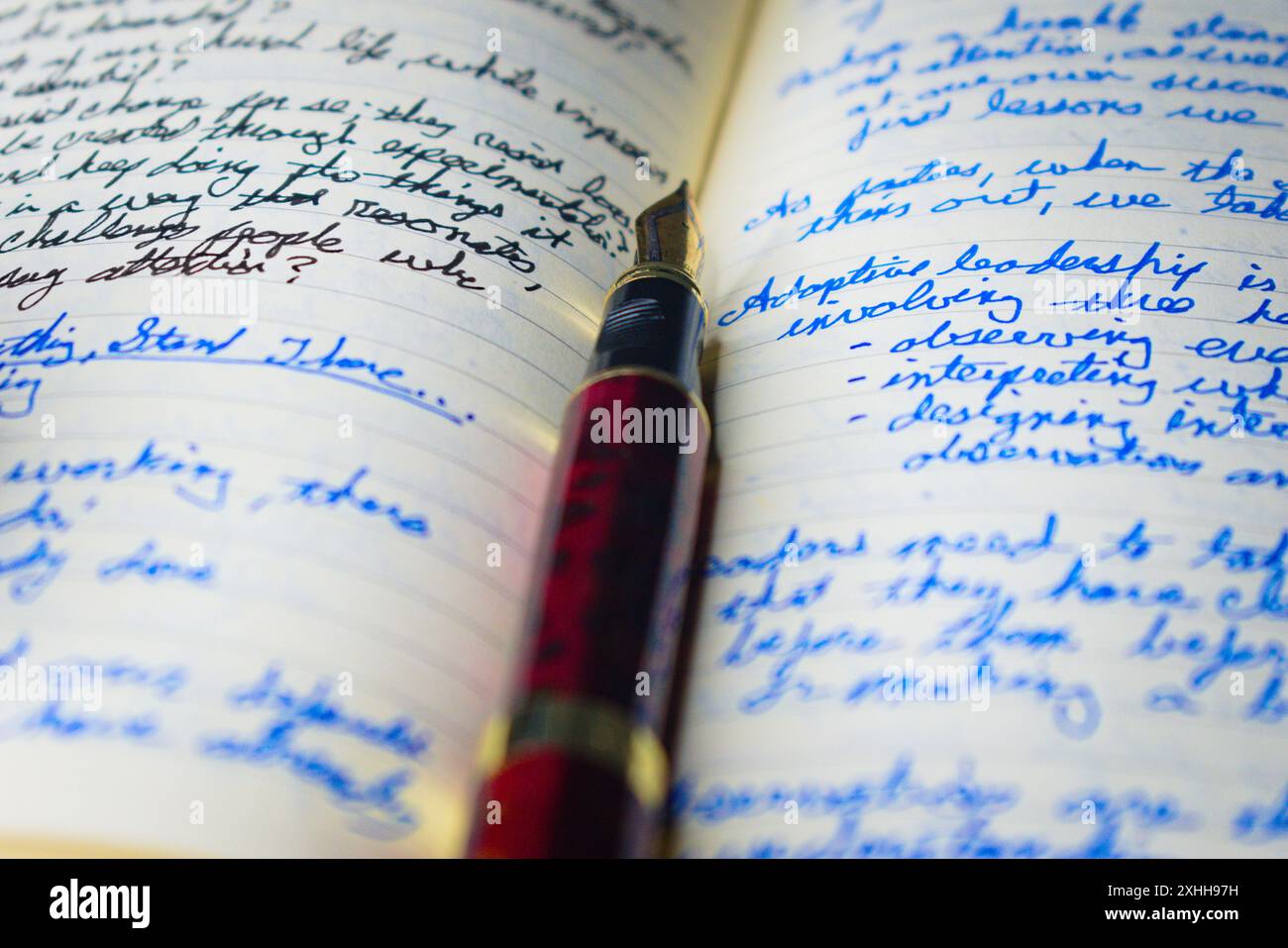 An uncapped fountain pen laying inside of an open journal Stock Photo ...