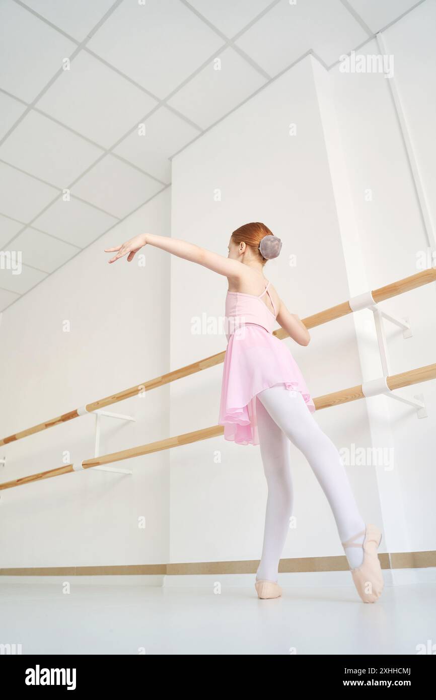 Young ballet girl at studio lesson. Training performance. Stretching ...