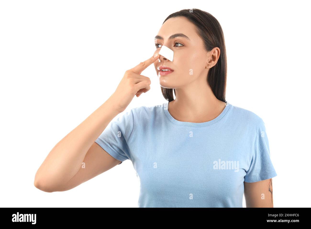 Young woman pointing at bandaged nose on white background. Plastic ...