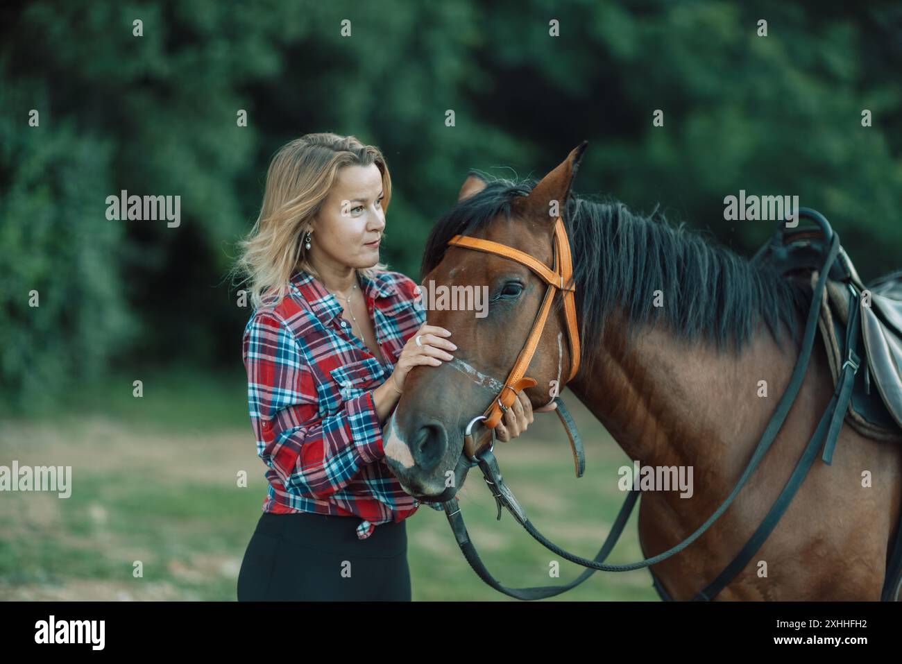 Happy blonde with horse in forest. Woman and a horse walking through ...