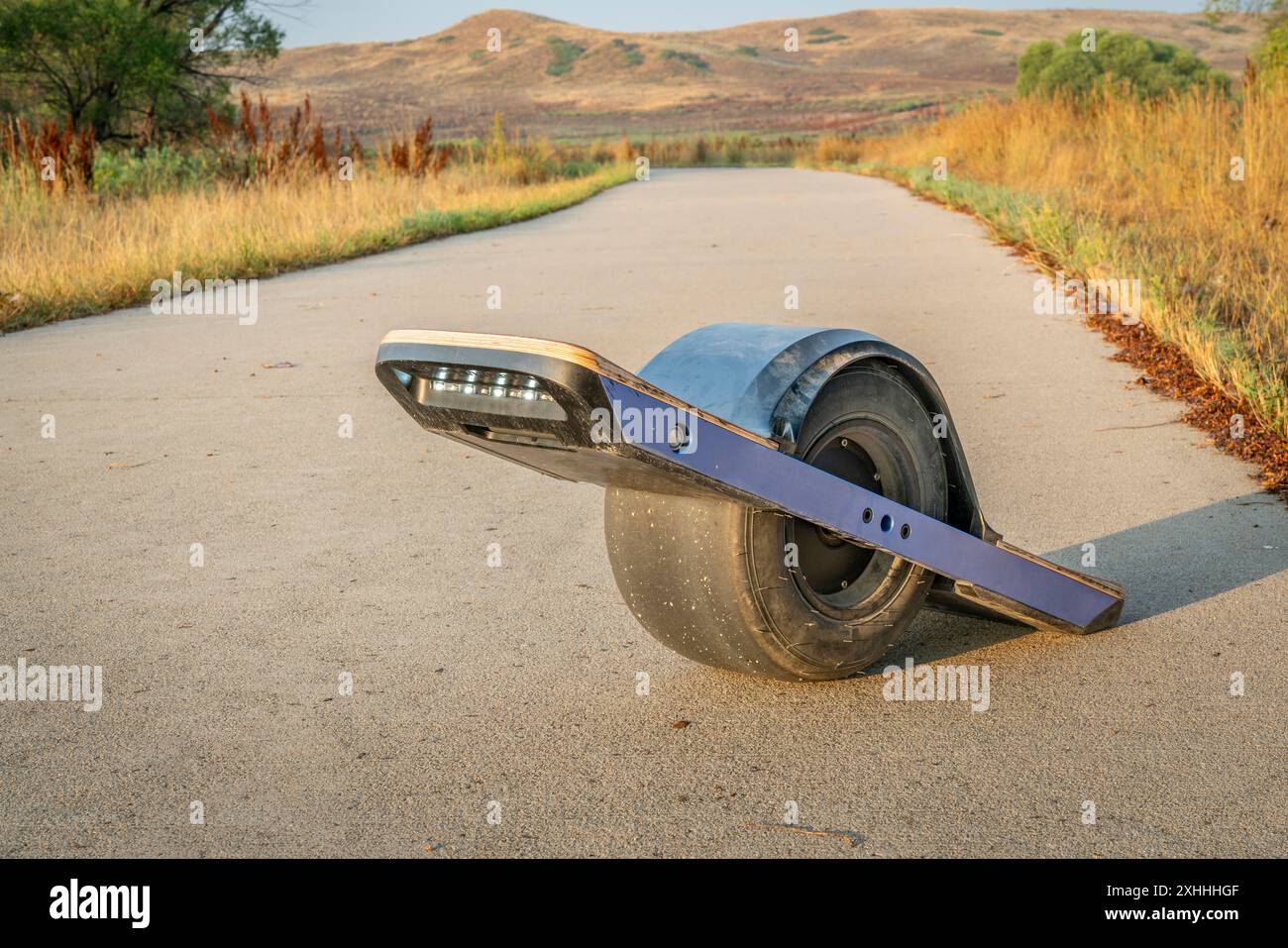 One-wheeled electric skateboard in the late summer morning on the ...