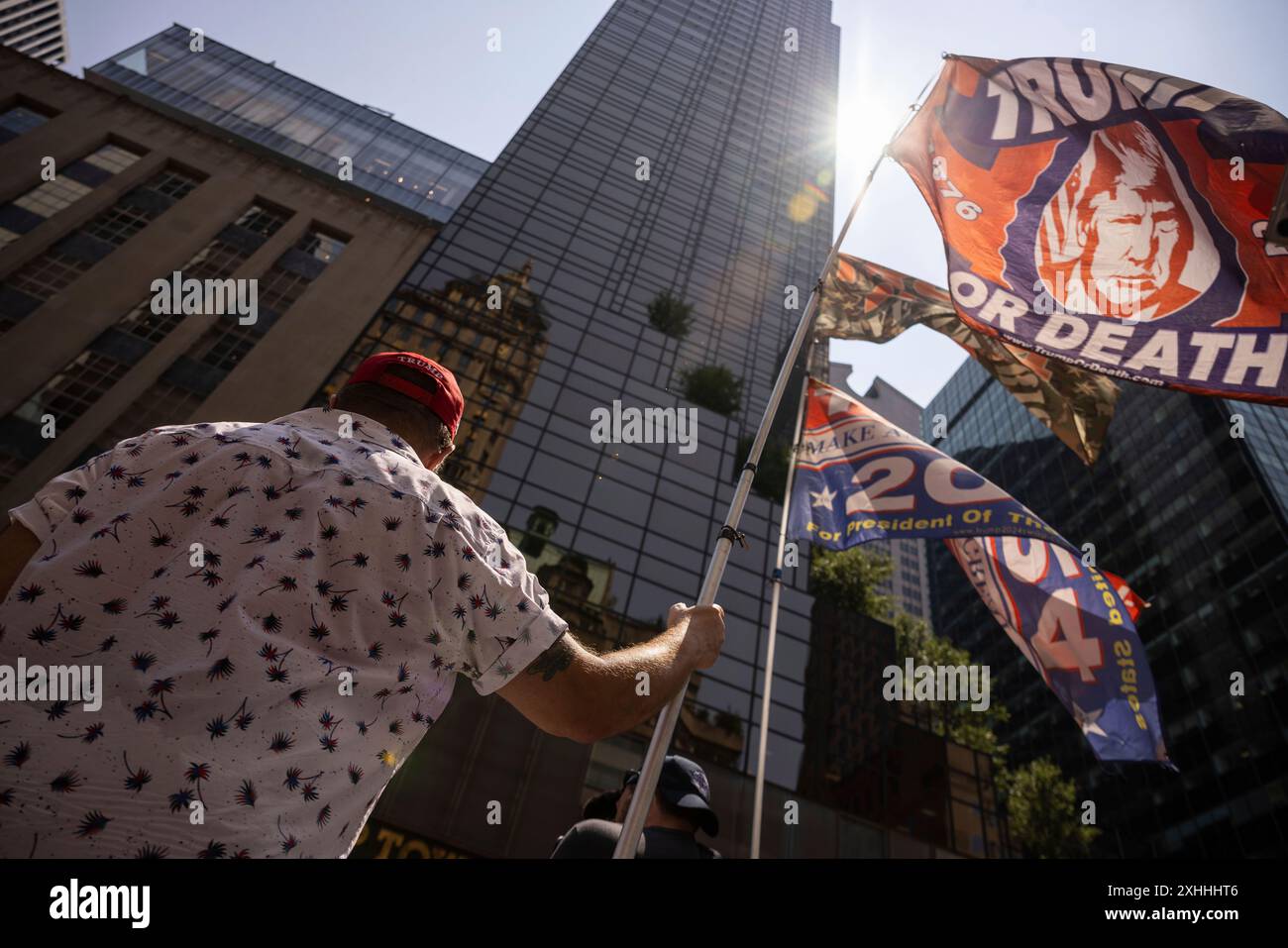 A supporter of former President Donald Trump raises Trump 2024 flags ...