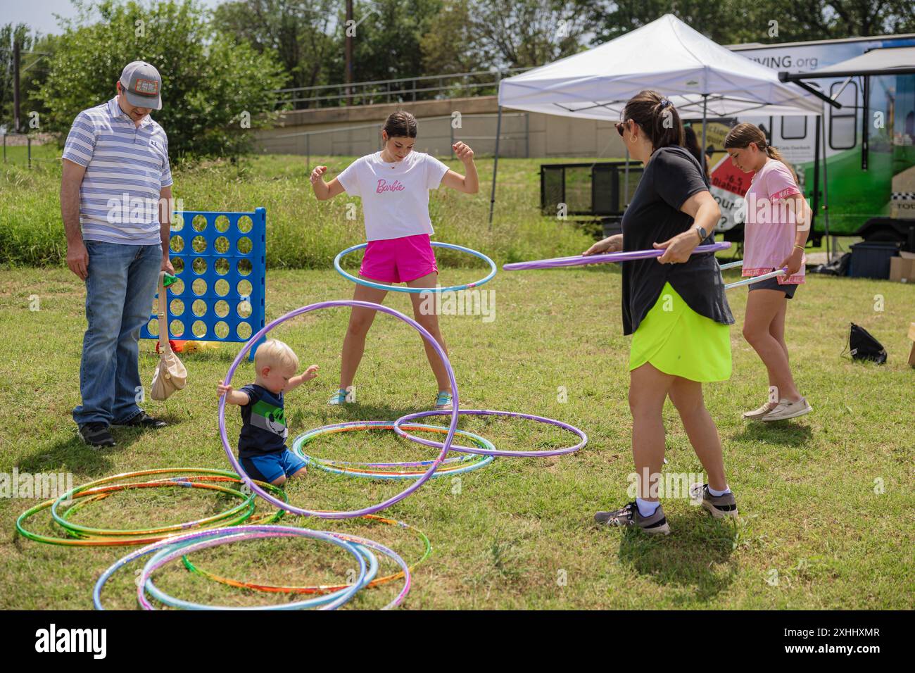 A group of people enjoying outdoor activities with hula hoops and a ...