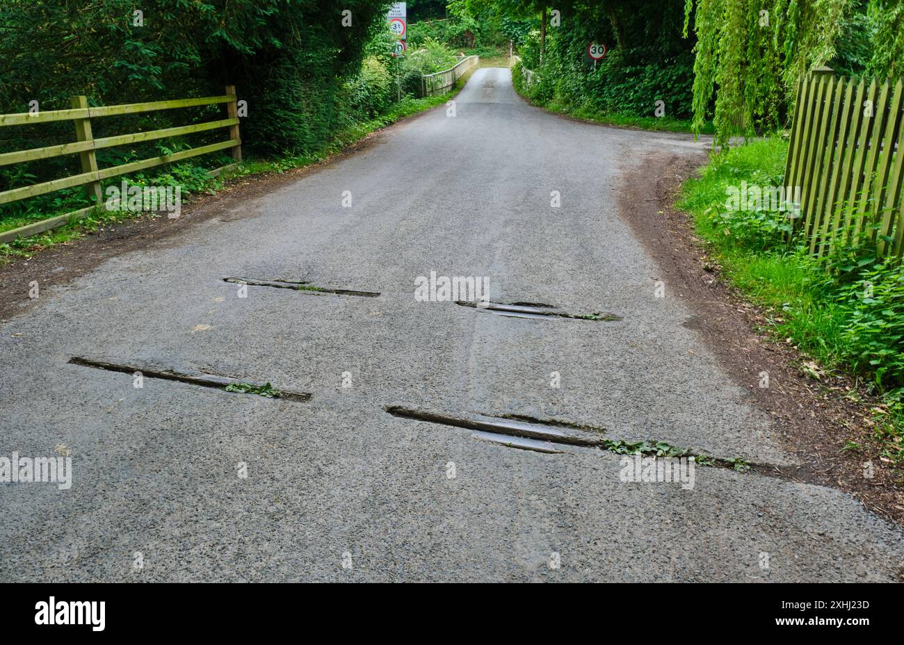 Disued railway line crossing the road near Llandinam Bridge, Llandinam ...