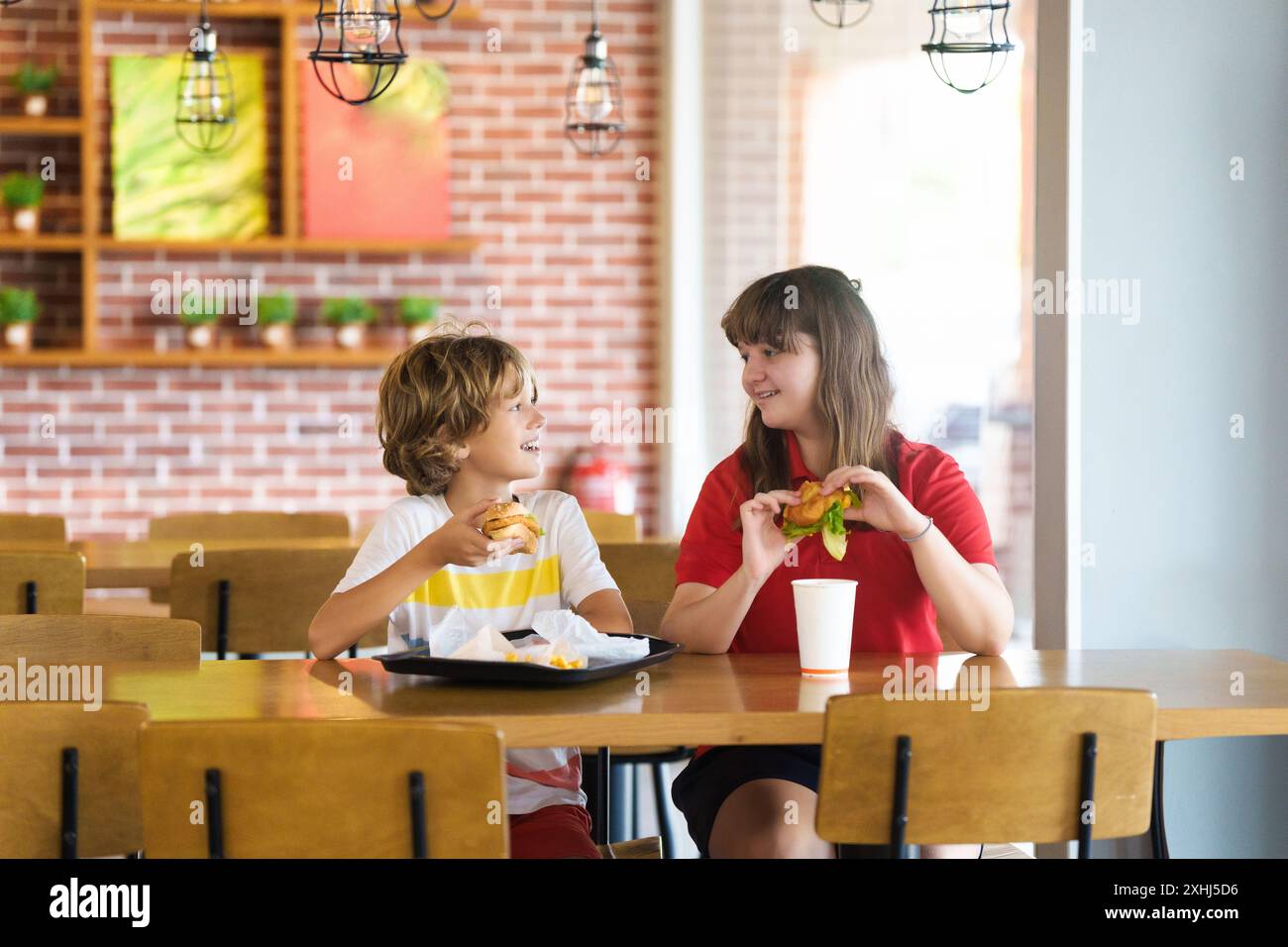 Kids eating fastfood. Unhealthy junk food. Children eat burger, chips ...