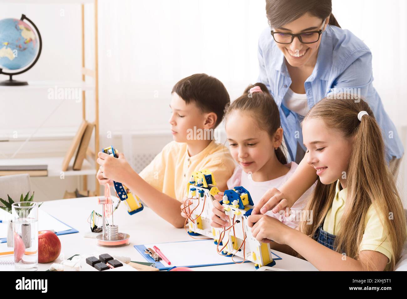 Elementary School Students Building Robots With Teacher Stock Photo - Alamy