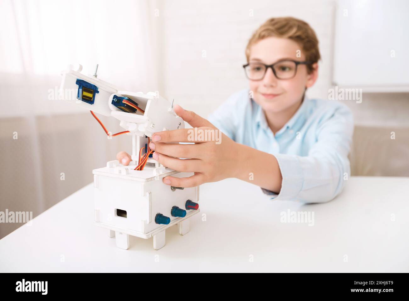 Boy Assembling Robotic Arm Model at Desk Stock Photo - Alamy