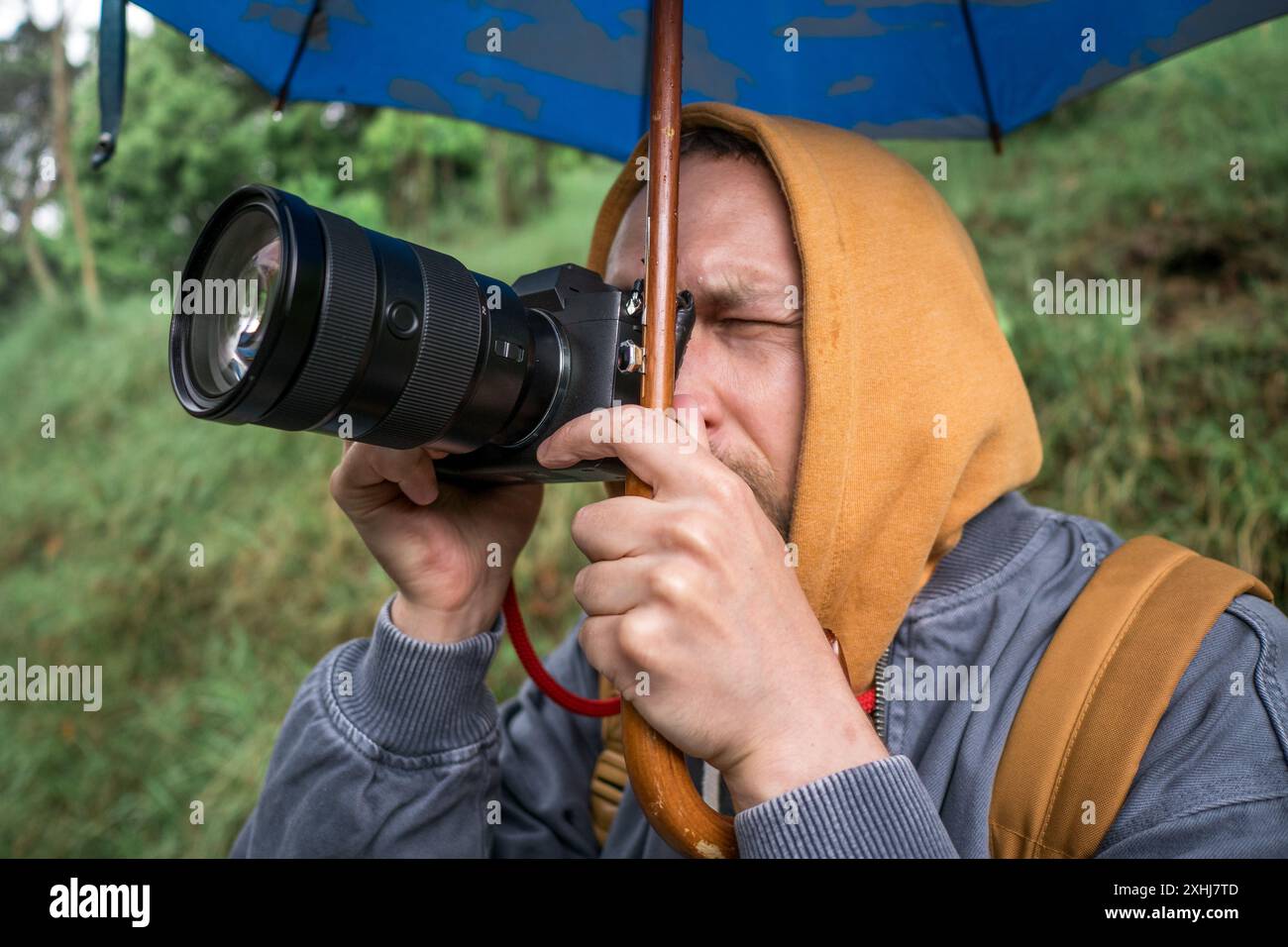 Photographer captures photos under umbrella, protecting camera from ...