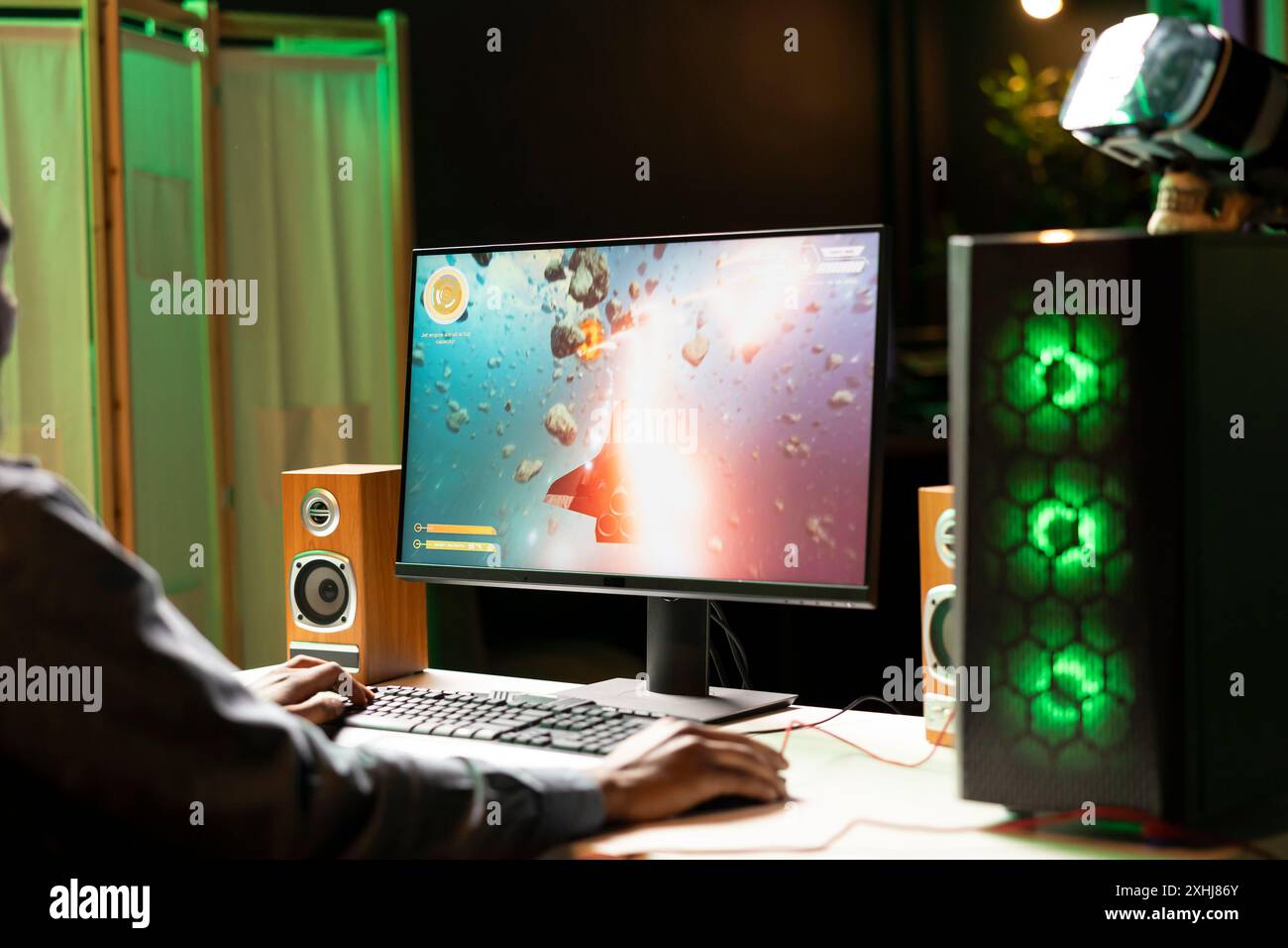 Gamer in neon lit apartment home shooting meteorites in spaceship ...