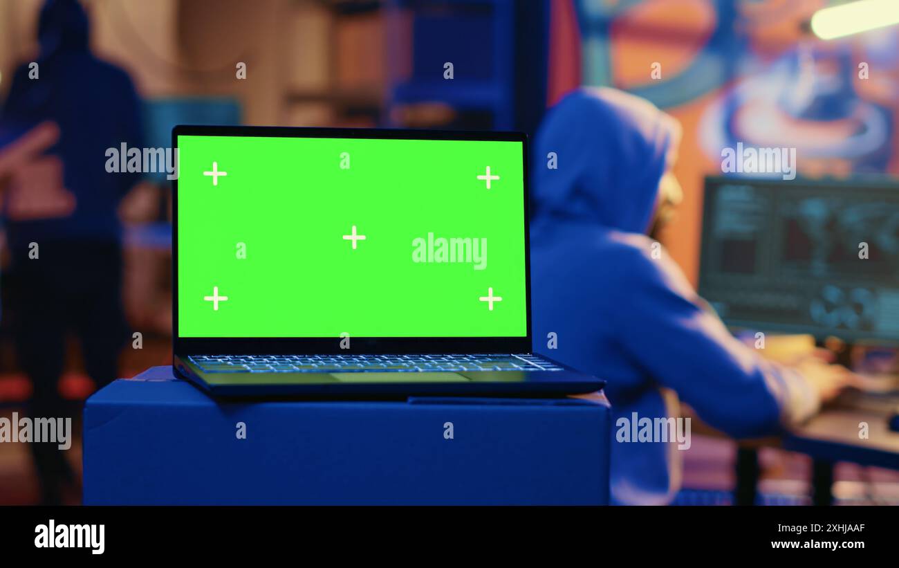 Green screen laptop used by hackers in underground hideout to write lines of code, developing ...