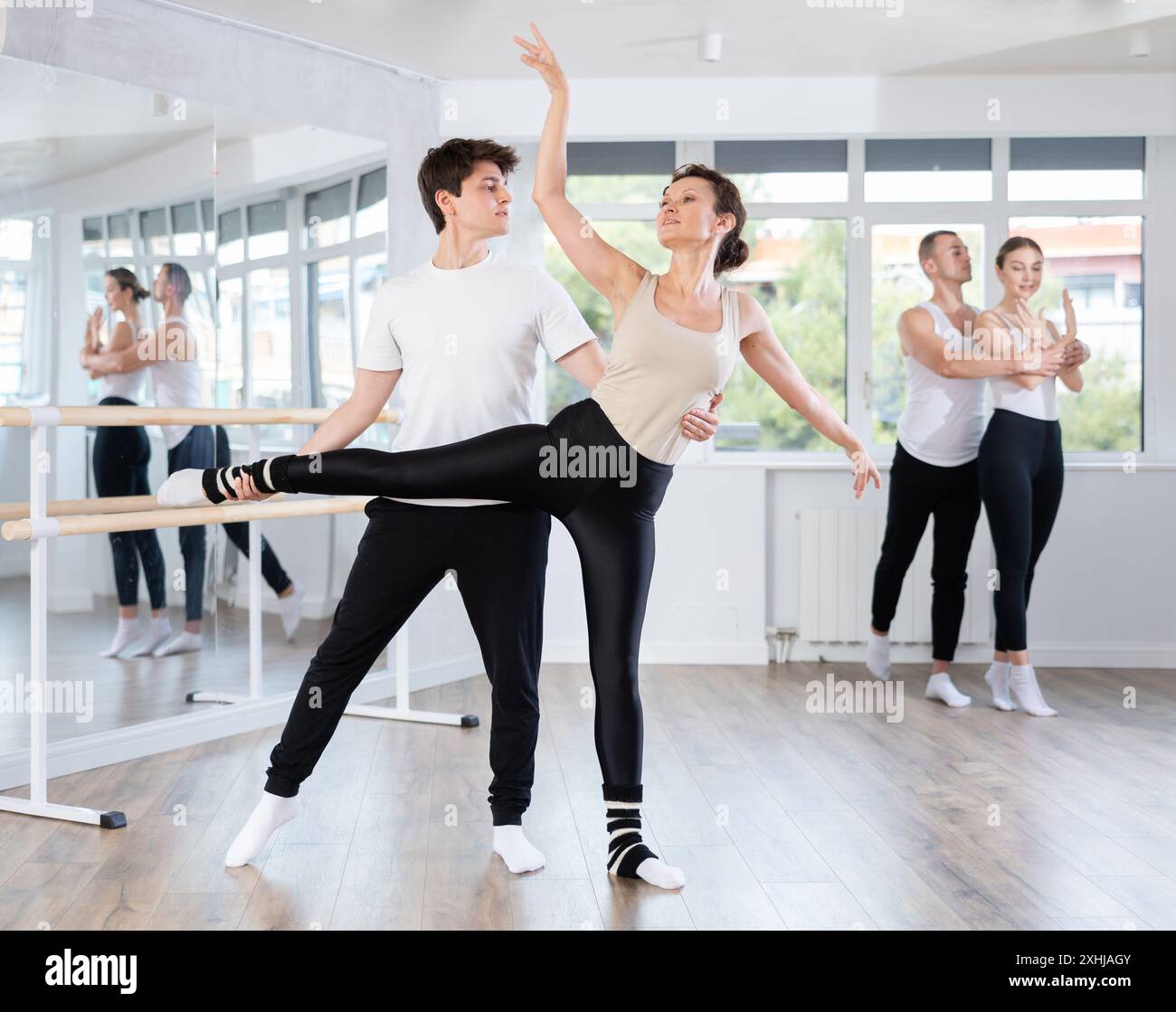 Young ballet dancer supporting female partner in challenging movements ...