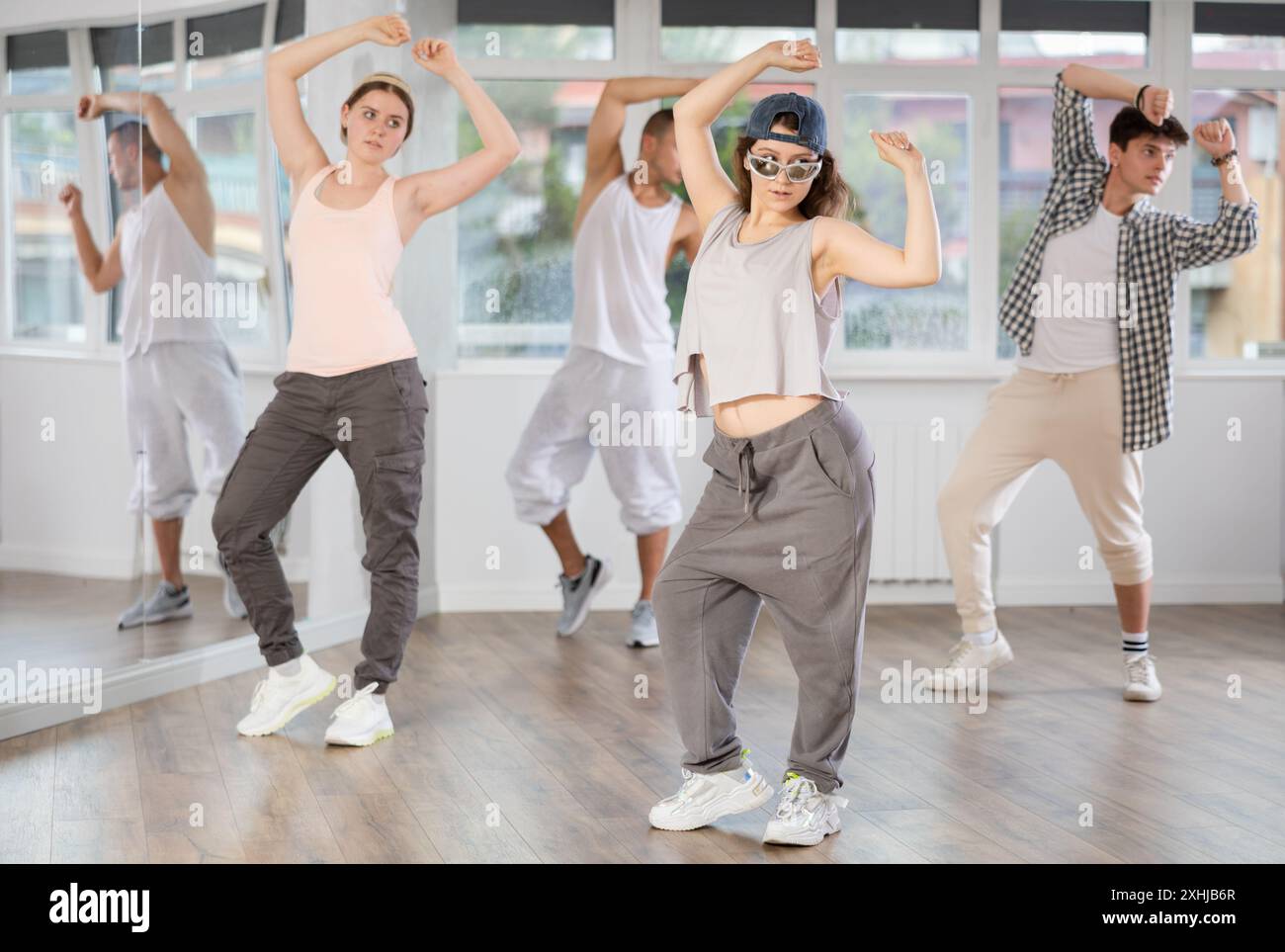 Young girl standing performs basic hip hop movements in front of group ...