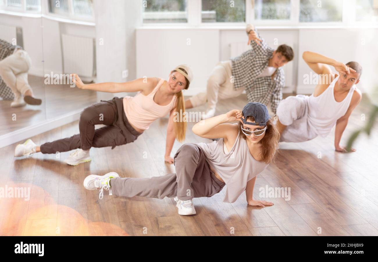 Girl and her students perform hip hop dance on one bent leg, movement ...