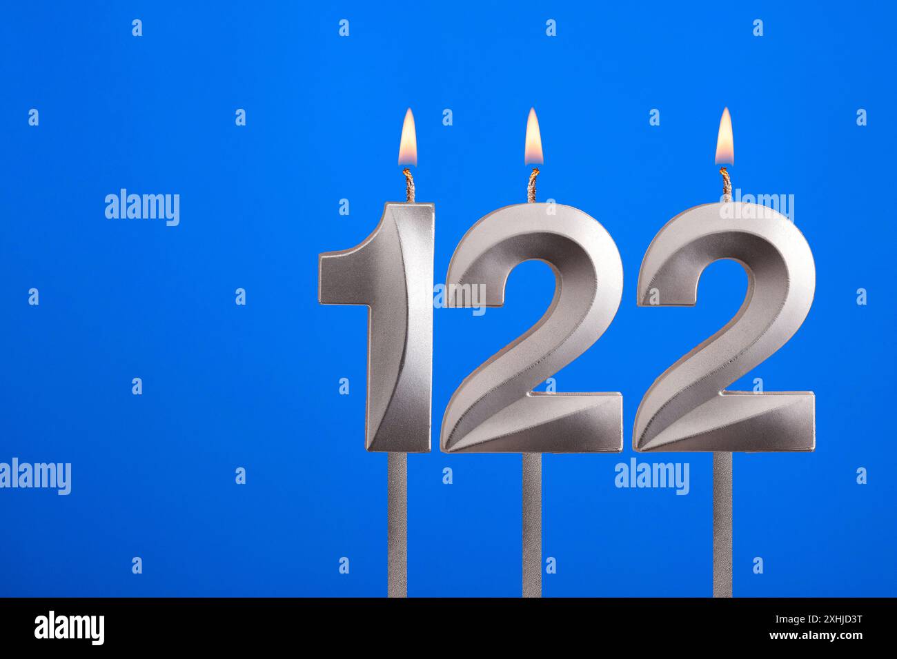 Birthday number 122 - Candle lit on blue background Stock Photo - Alamy