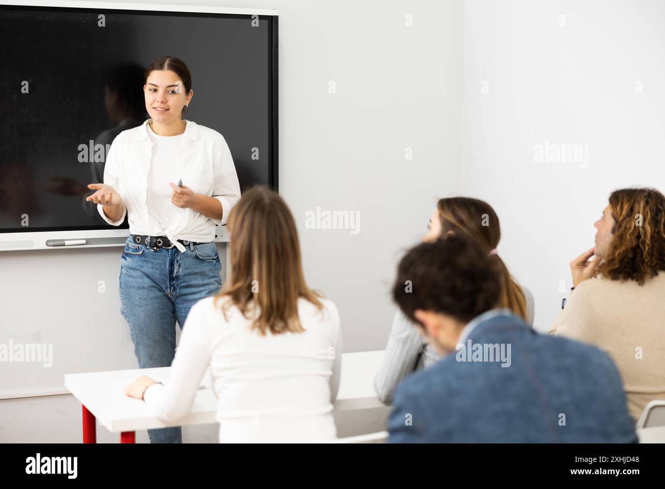 Young female teacher giving lecture to group of student Stock Photo - Alamy