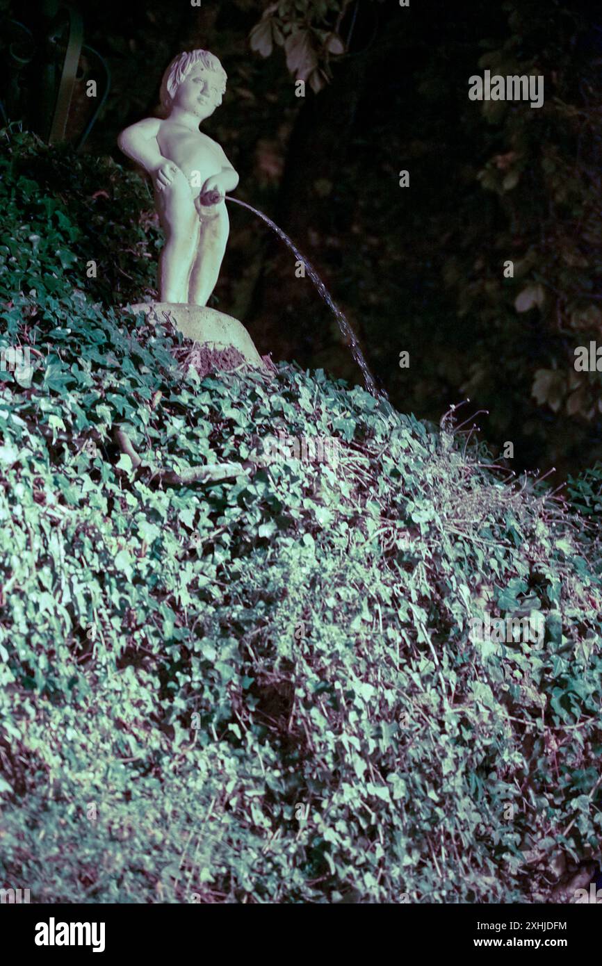 Stone statue of a child urinating in a garden in the Alentejo town of ...