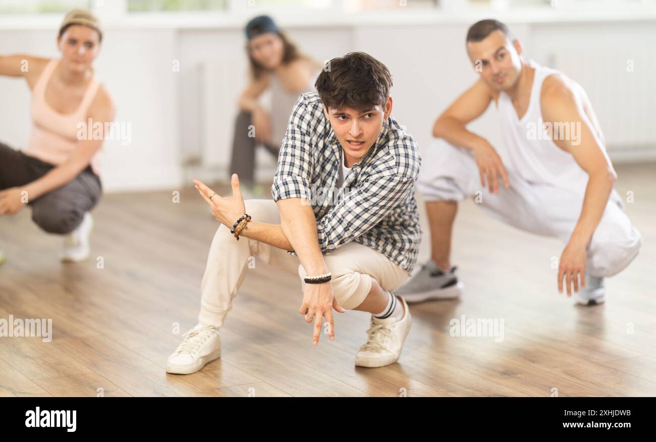 Young guy performing sitting pose of breakdance in training hall Stock ...