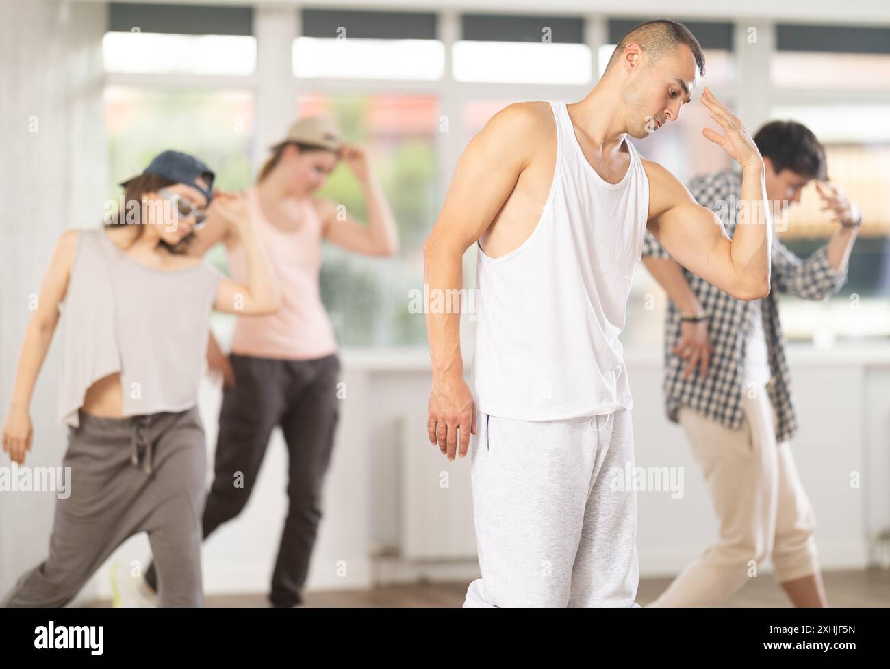 Young guy practicing hip hop slide moves in training hall Stock Photo ...