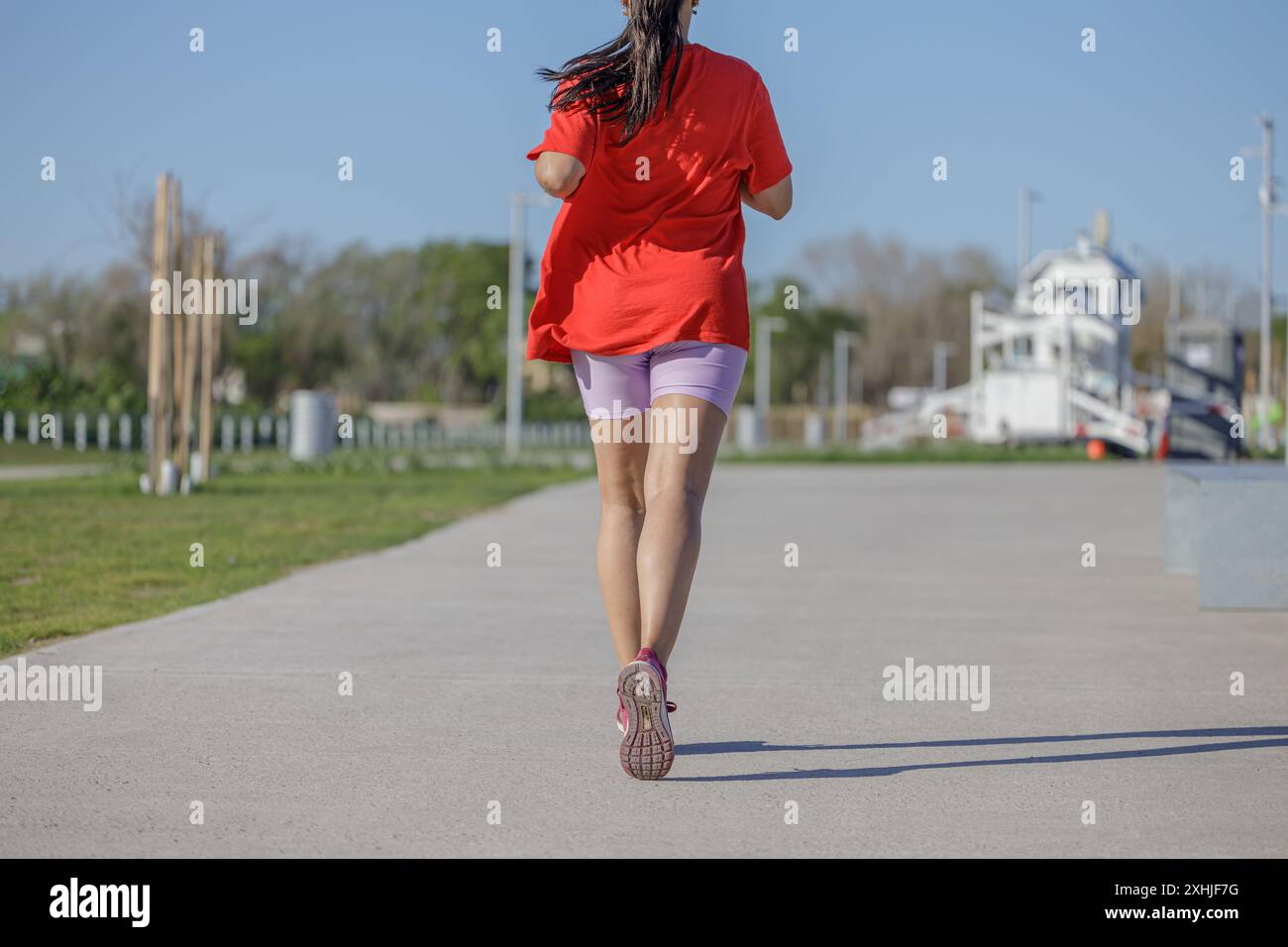 Latin girl with red t-shirt running, seen from behind Stock Photo - Alamy
